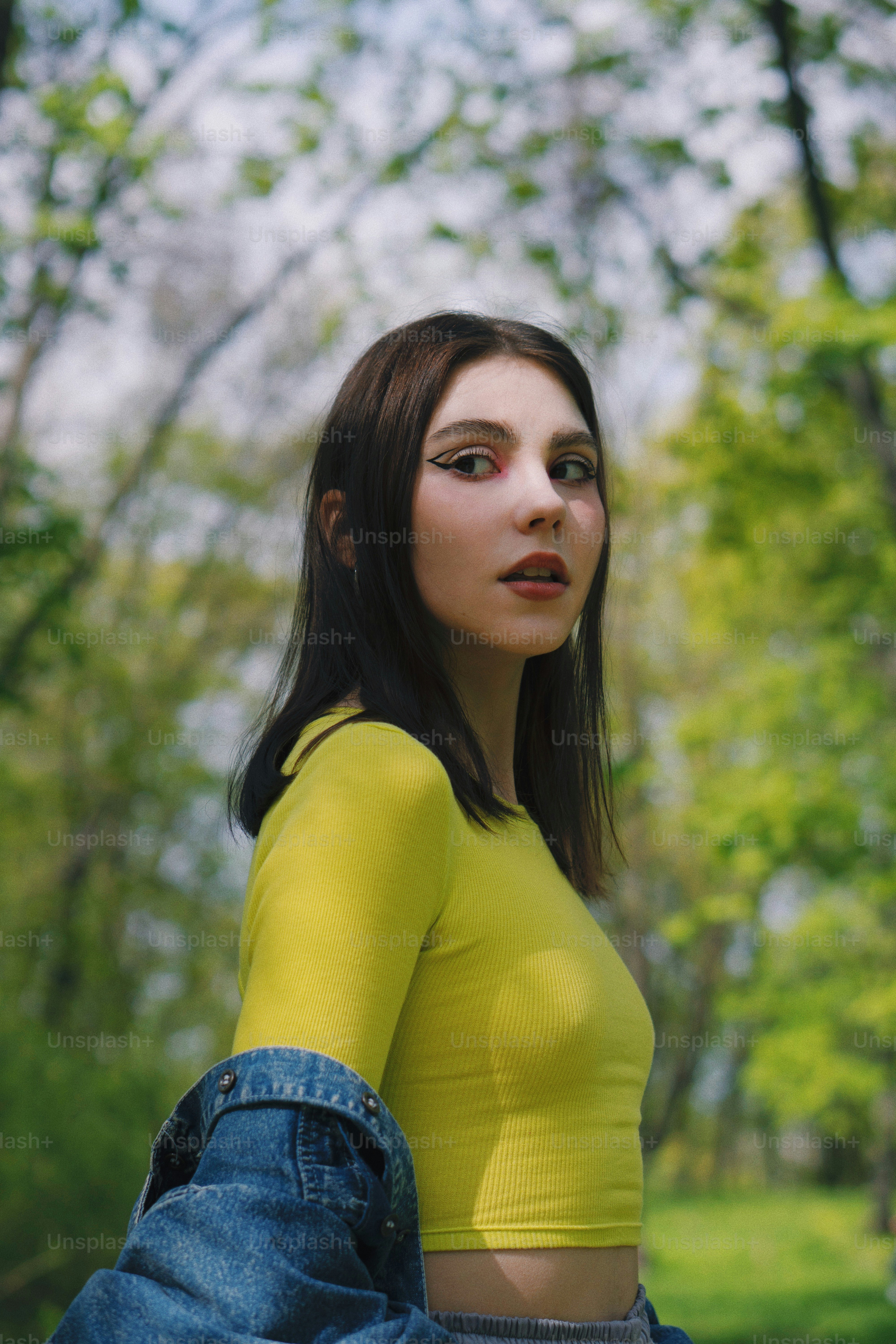 Una mujer con una camisa amarilla posa para una foto foto – Imagen de ...