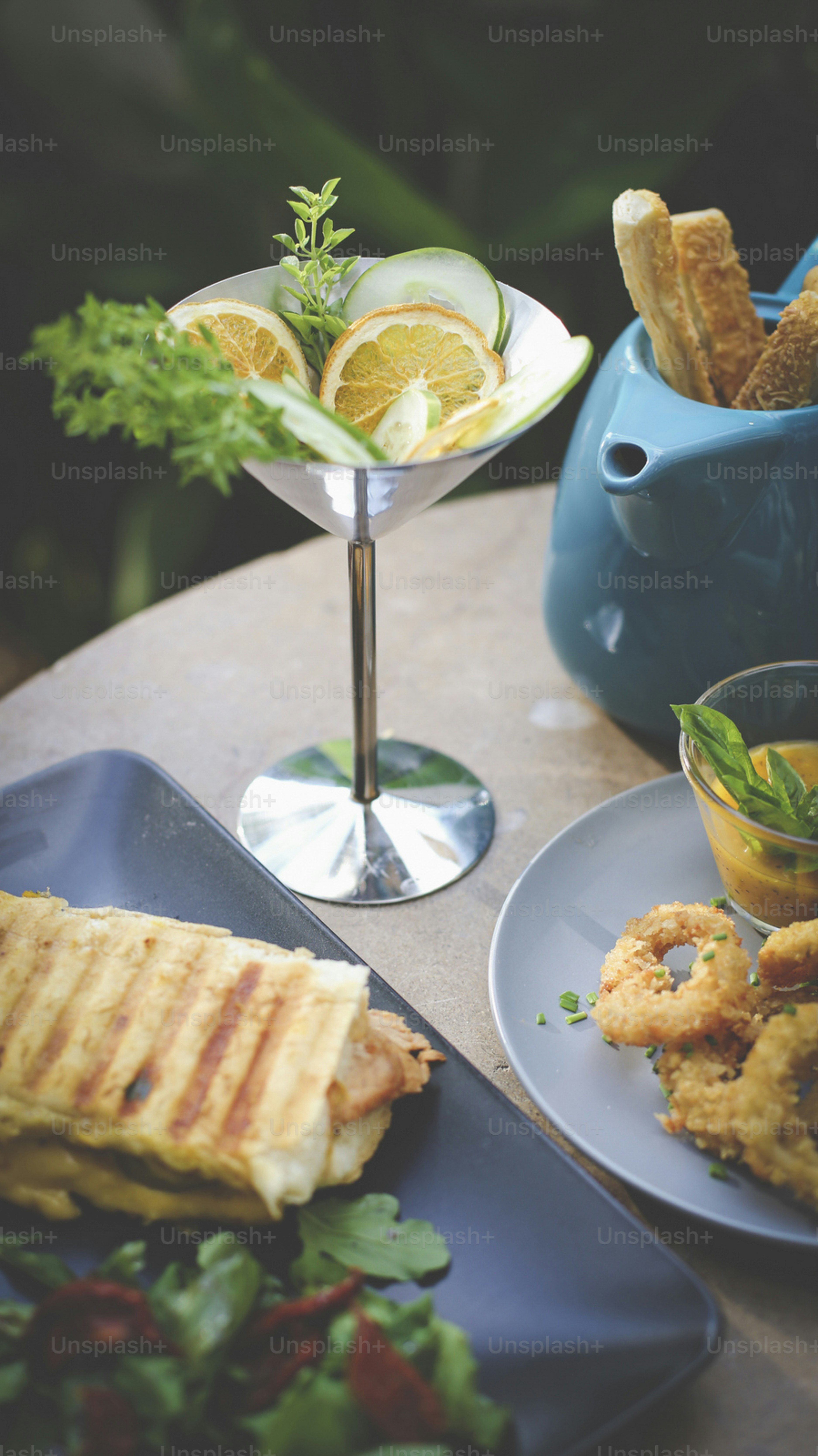 A table topped with plates of food and drinks photo – Panini Image on ...