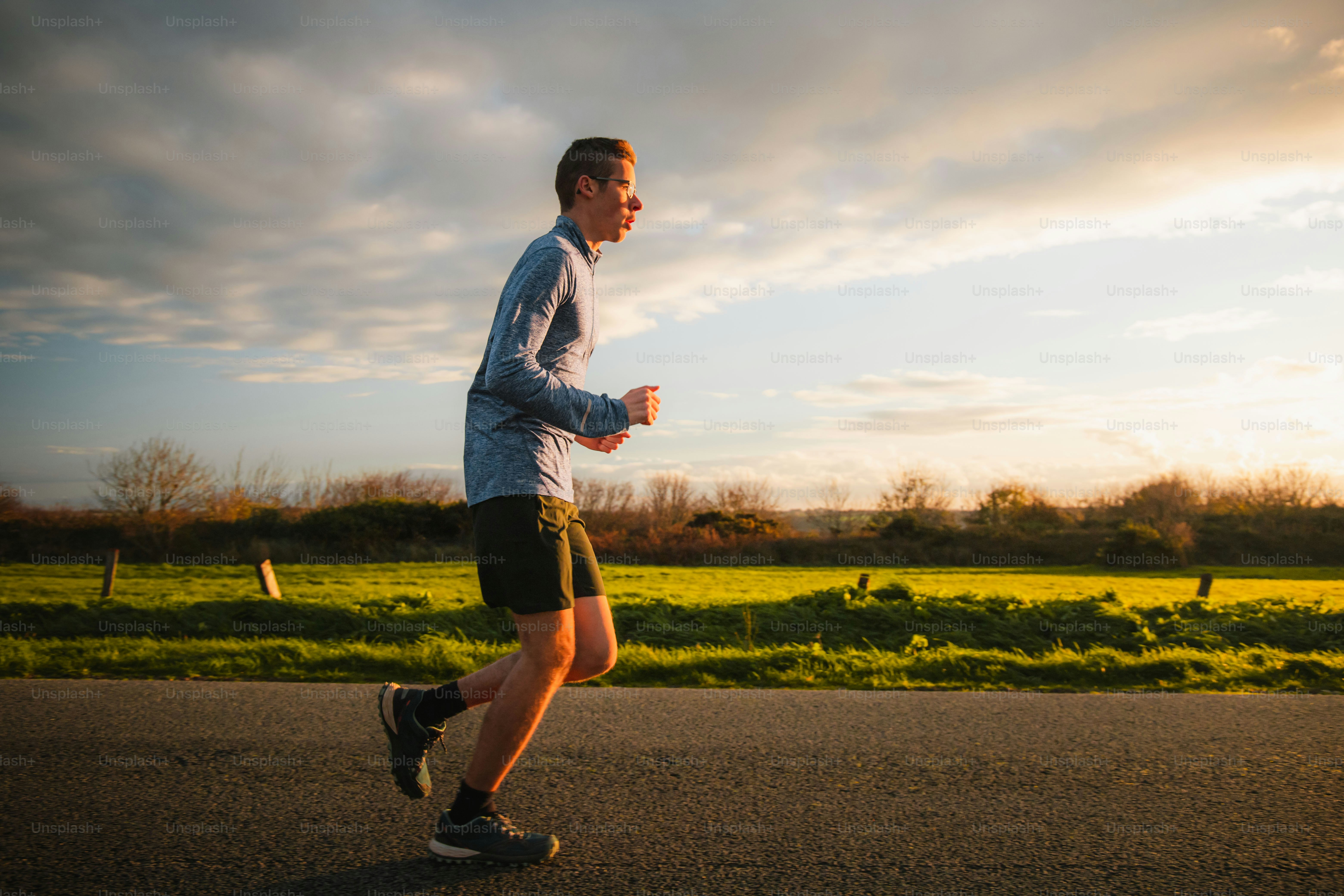 A man running down a road in the middle of the day photo – Running ...
