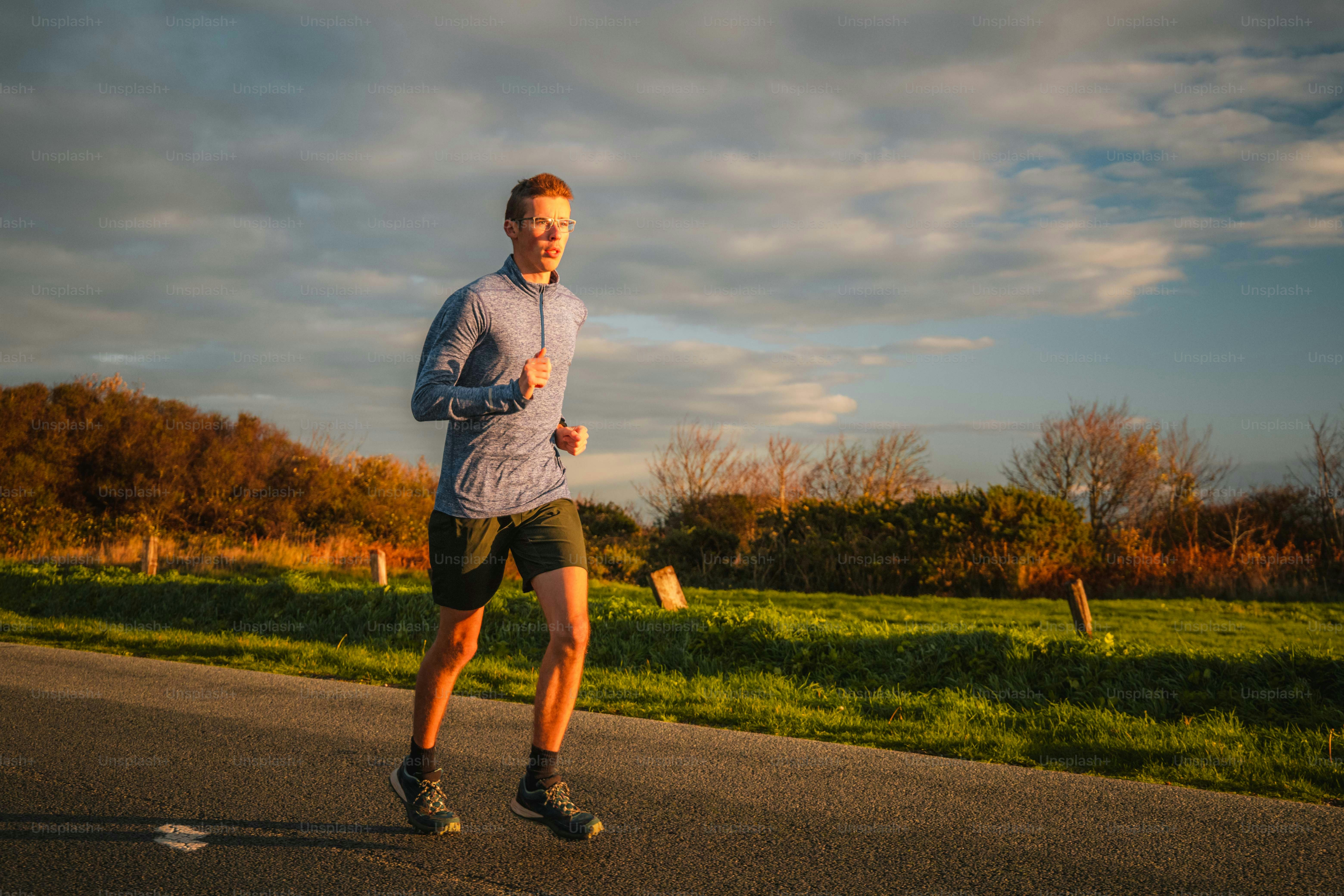 A man running down a road with a sky background photo – Runner Image on ...