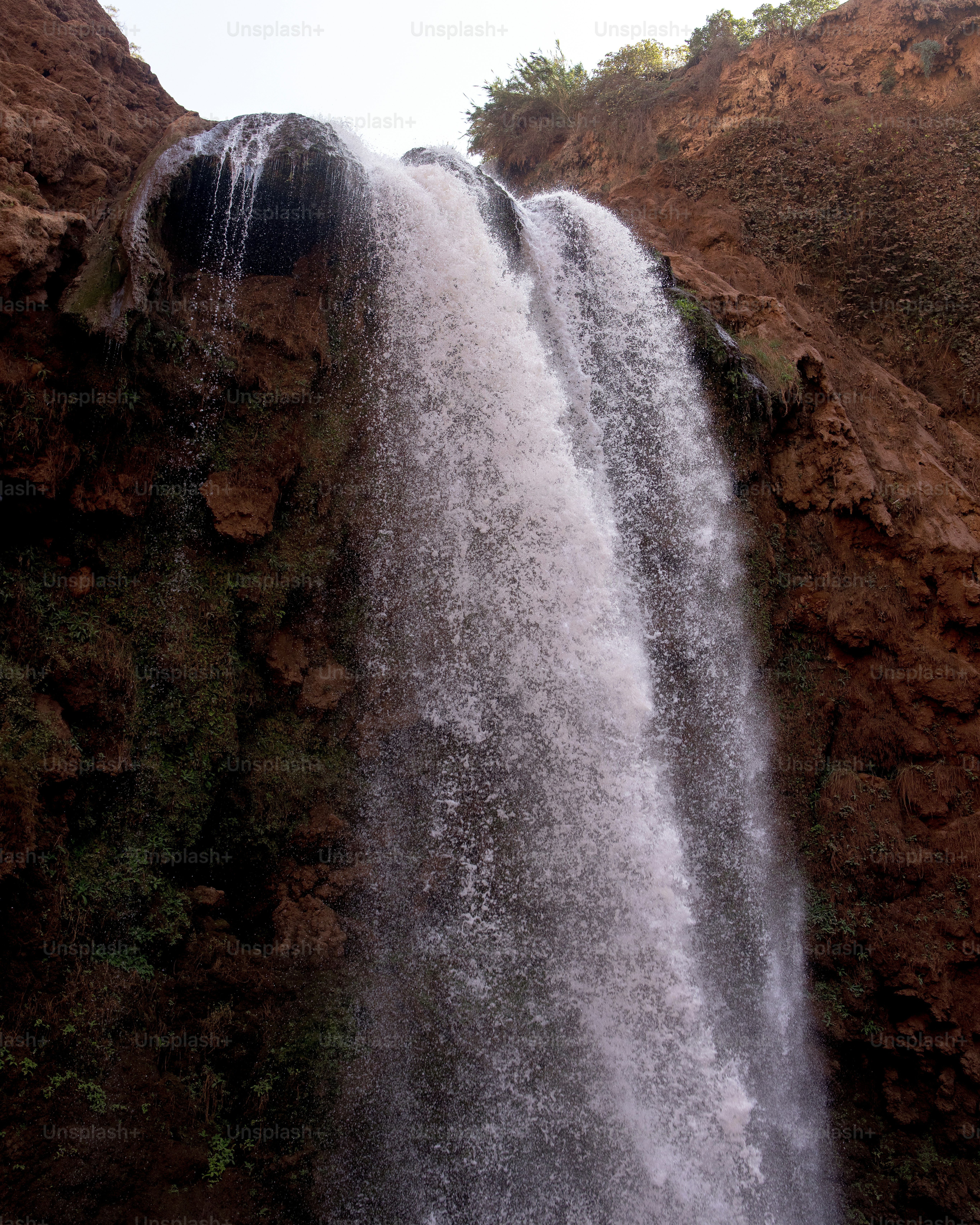 A very tall waterfall with lots of water coming out of it photo ...