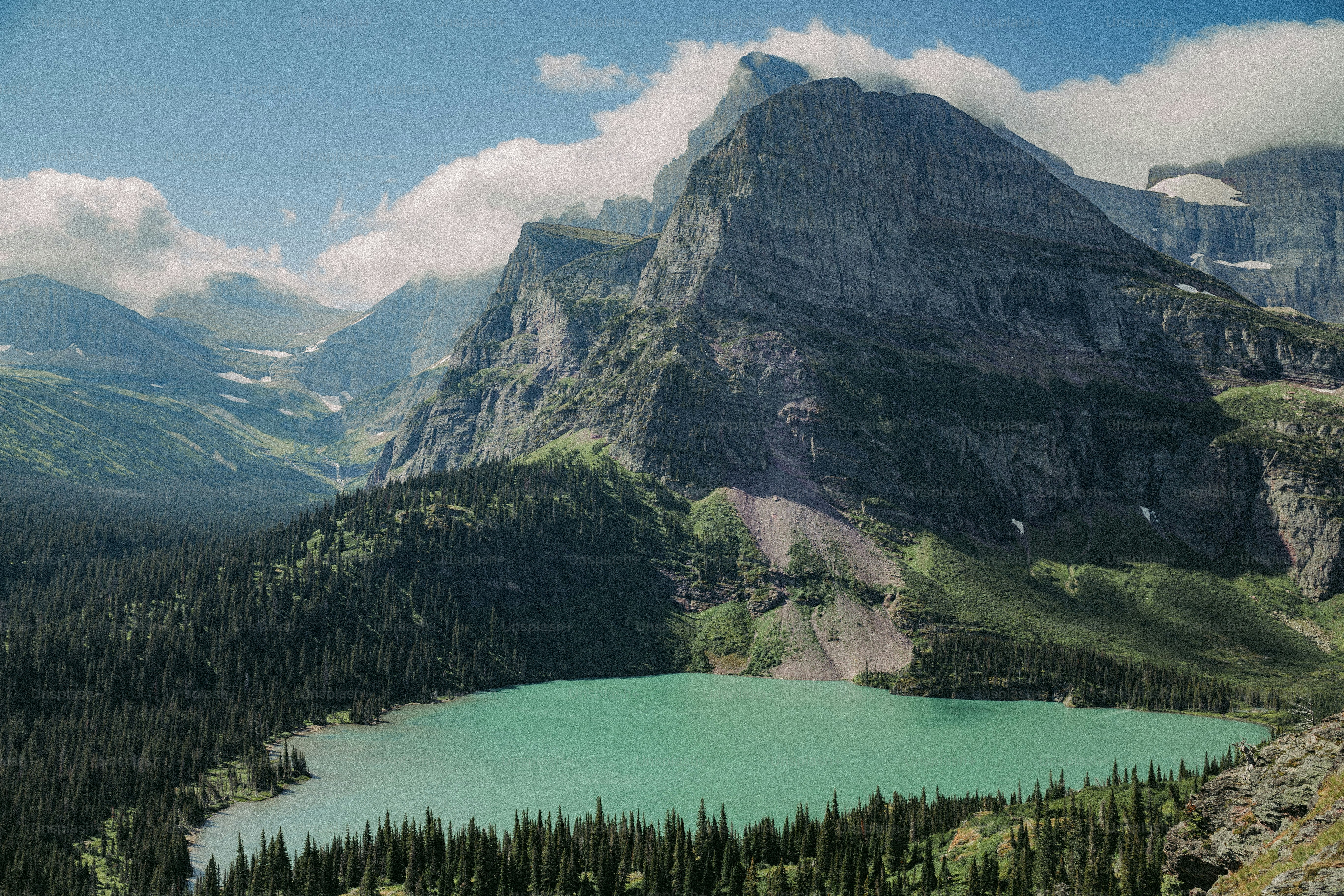 A scenic view of a mountain range with a lake in the foreground photo ...