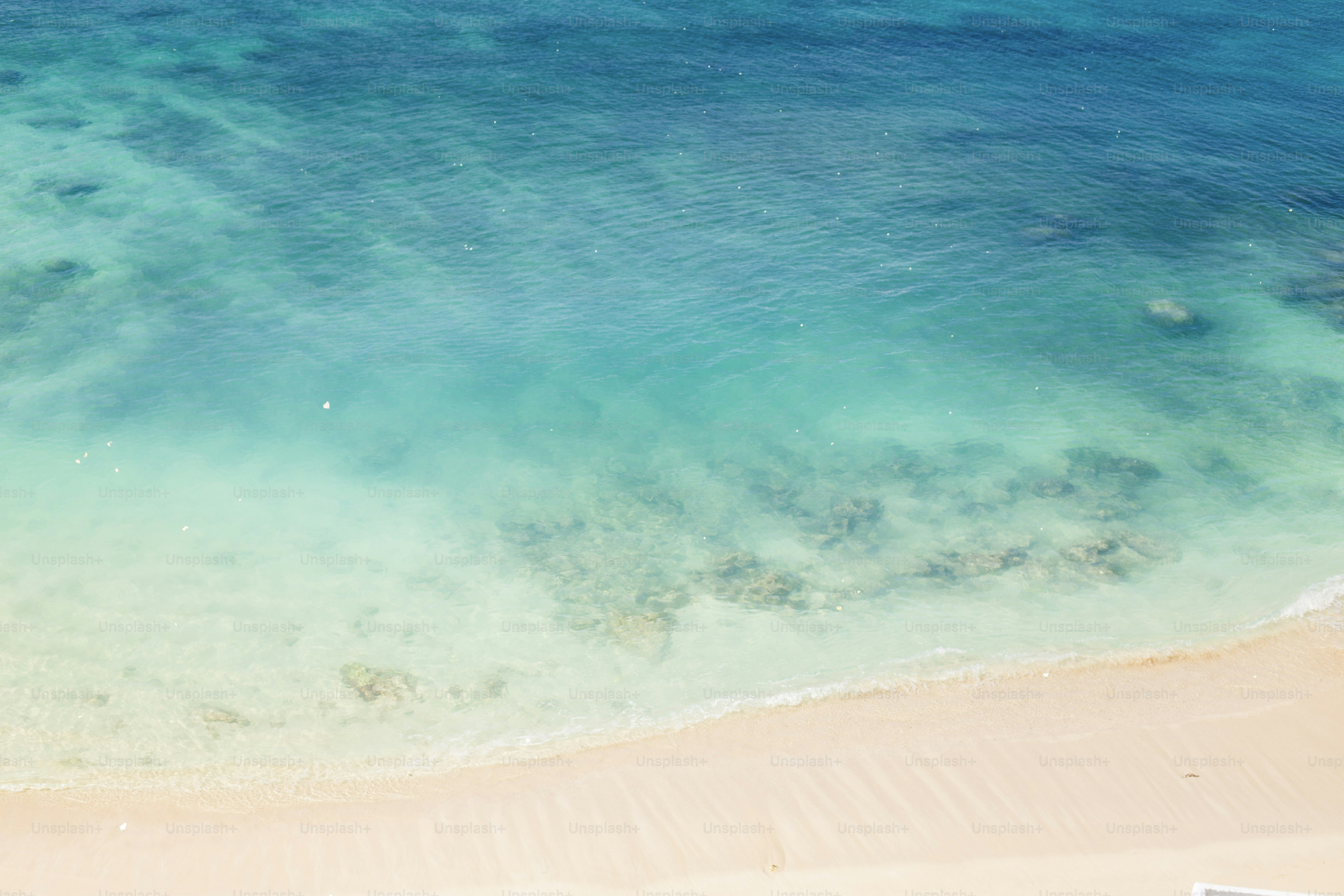 An aerial view of a sandy beach with clear blue water photo – Beach top ...