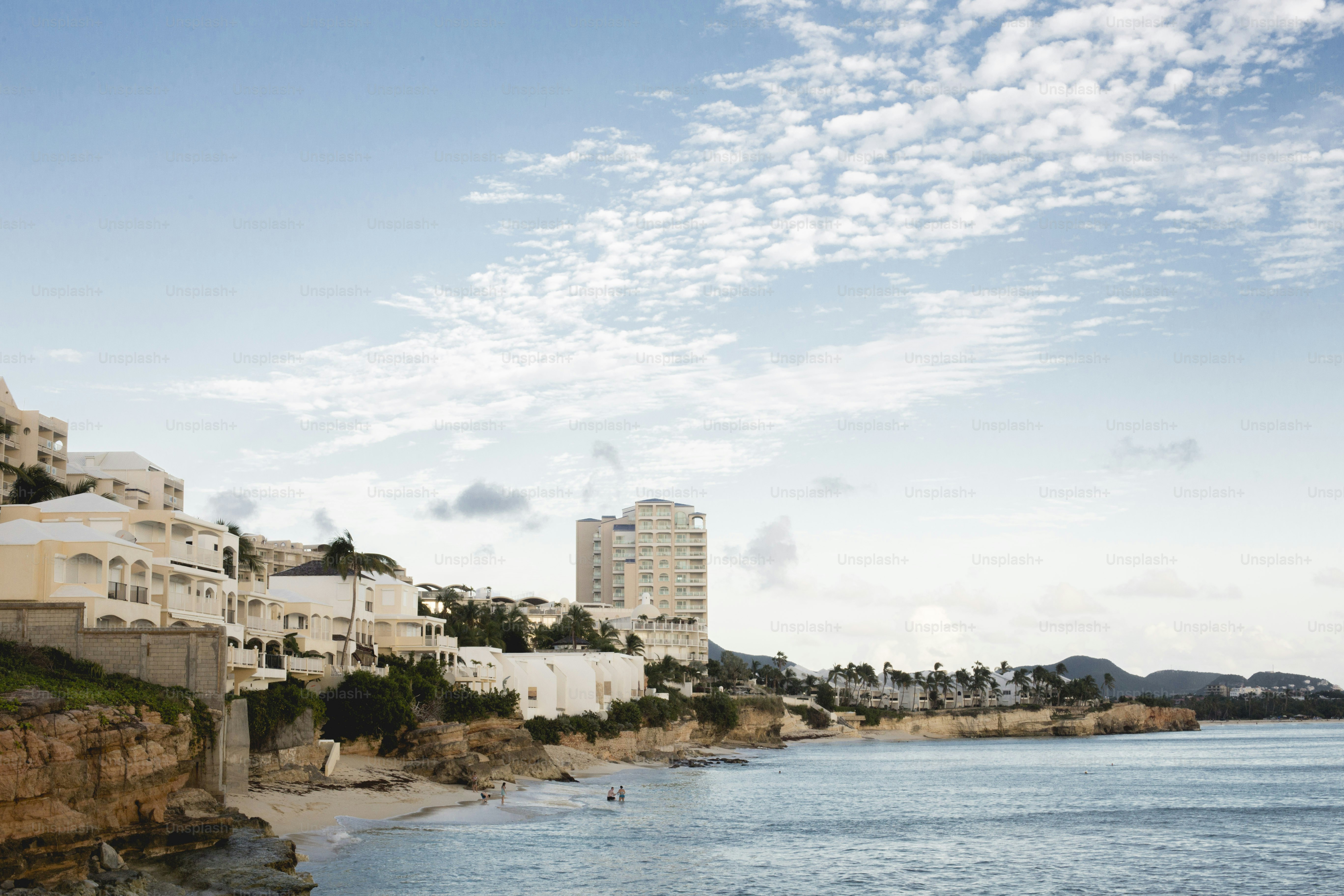 A view of a beach with buildings on the cliff photo – Sea Image on Unsplash