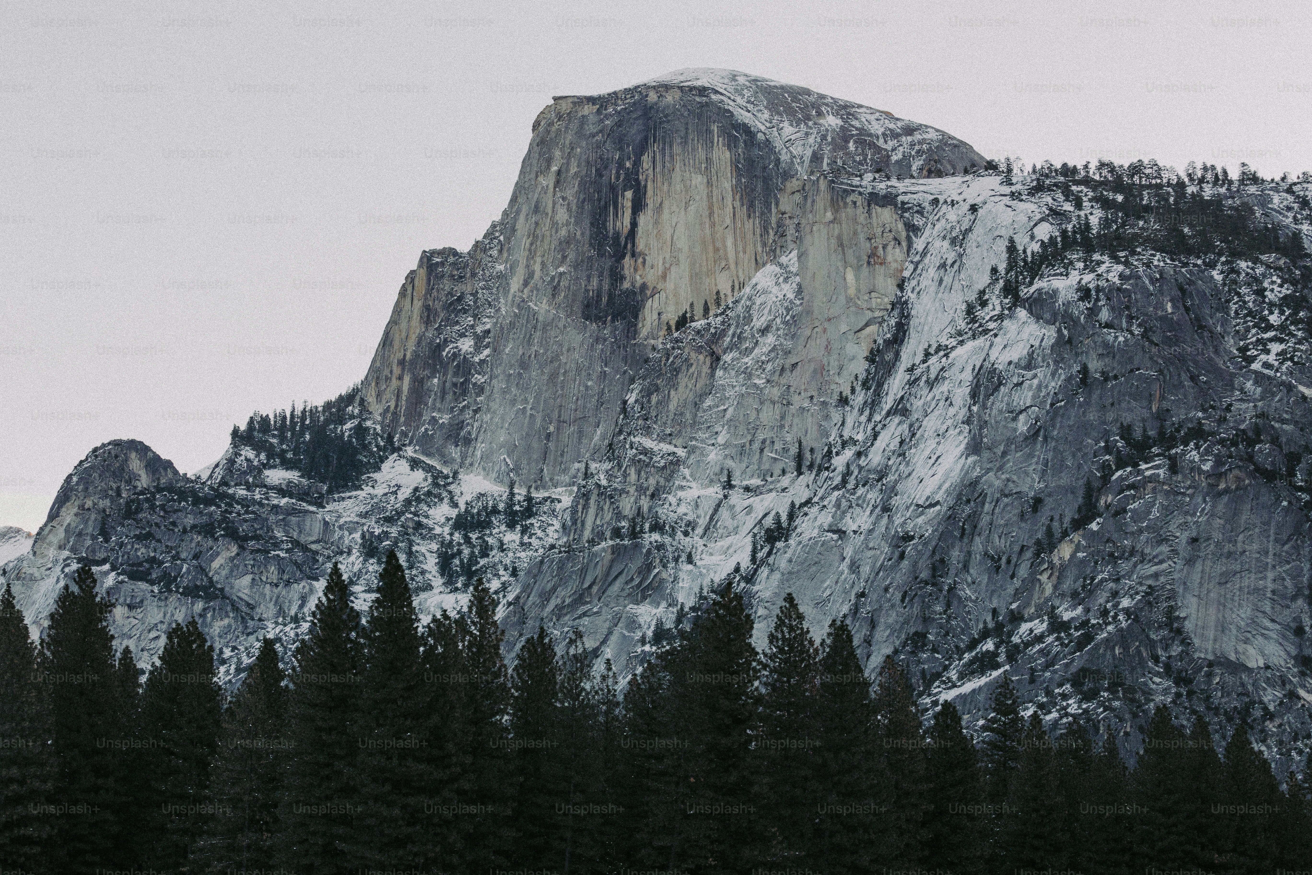 A very tall mountain with some trees in front of it photo – Cliff Image ...