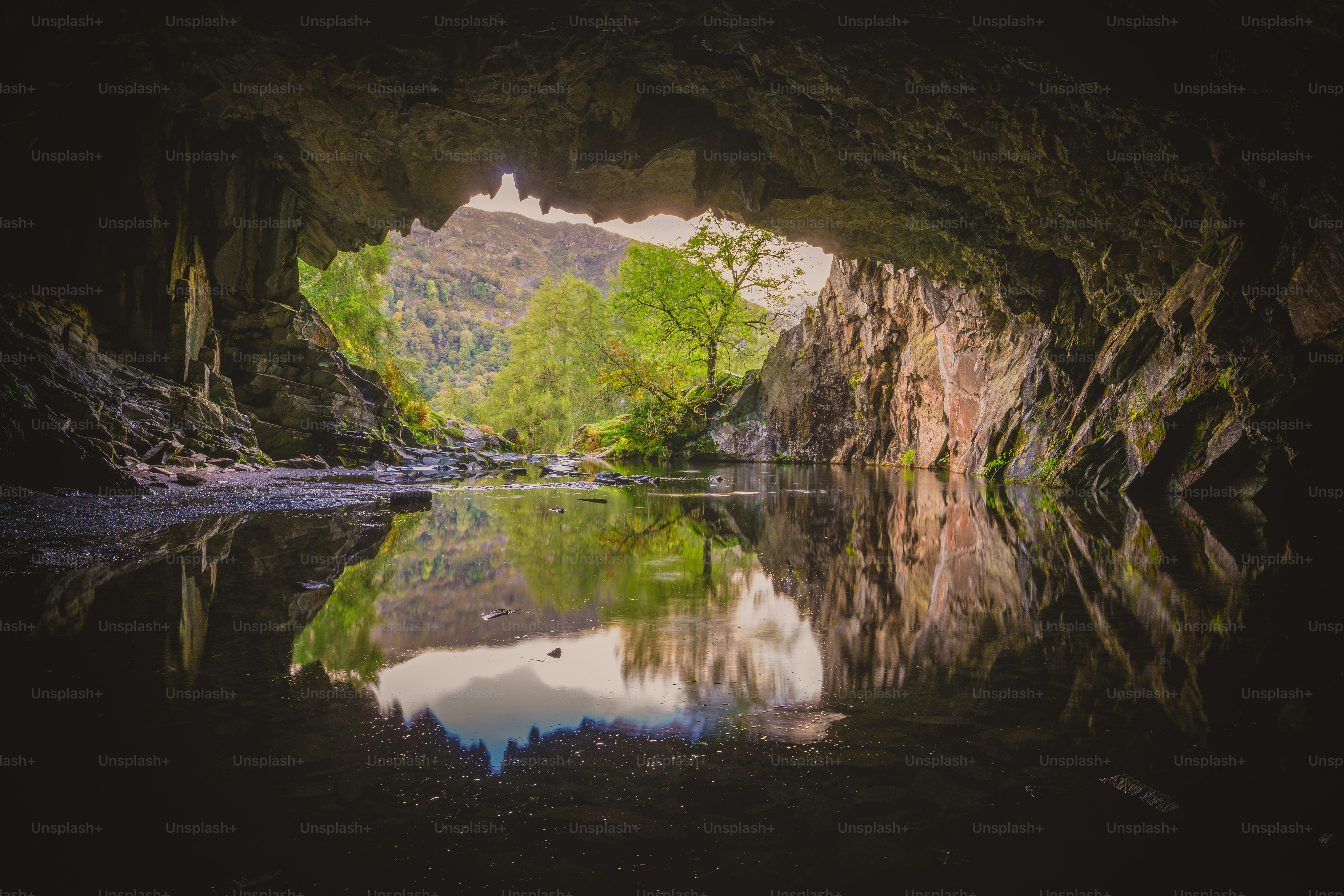 A large cave with a lake inside of it photo – Rydal Image on Unsplash