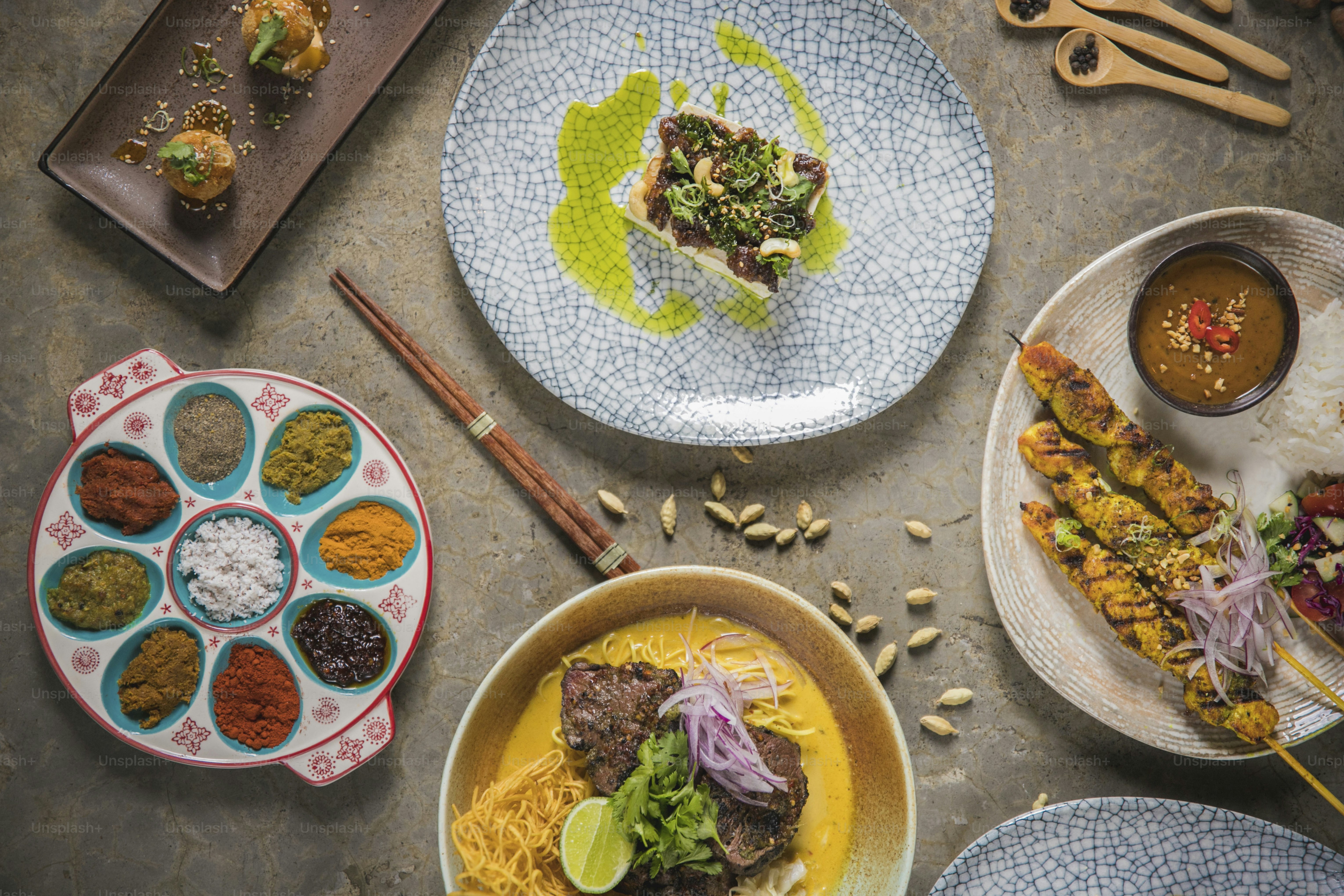 A table topped with plates filled with food photo – Indian cuisine ...