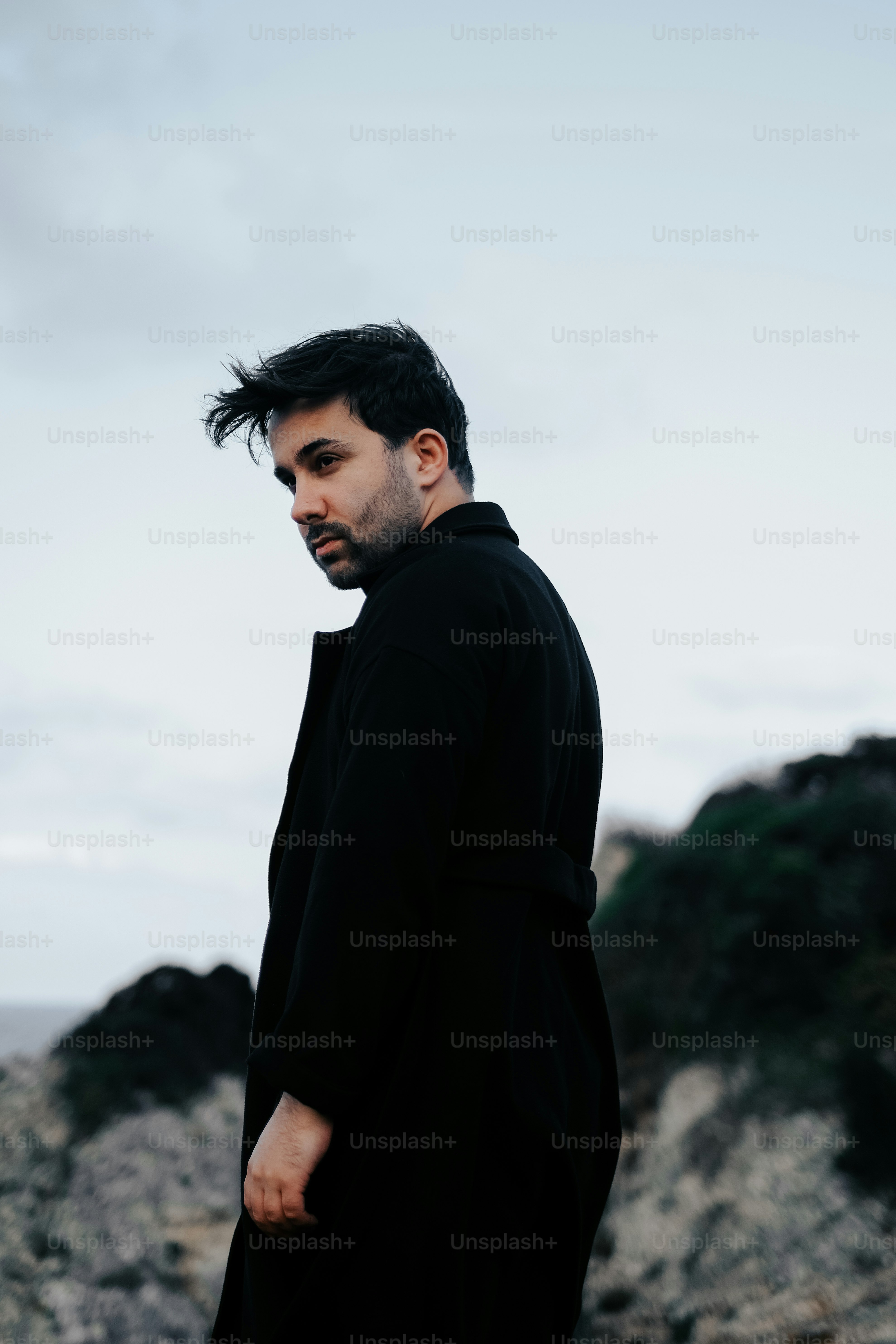 Foto Un hombre parado en la cima de una ladera rocosa – Hombre con ...