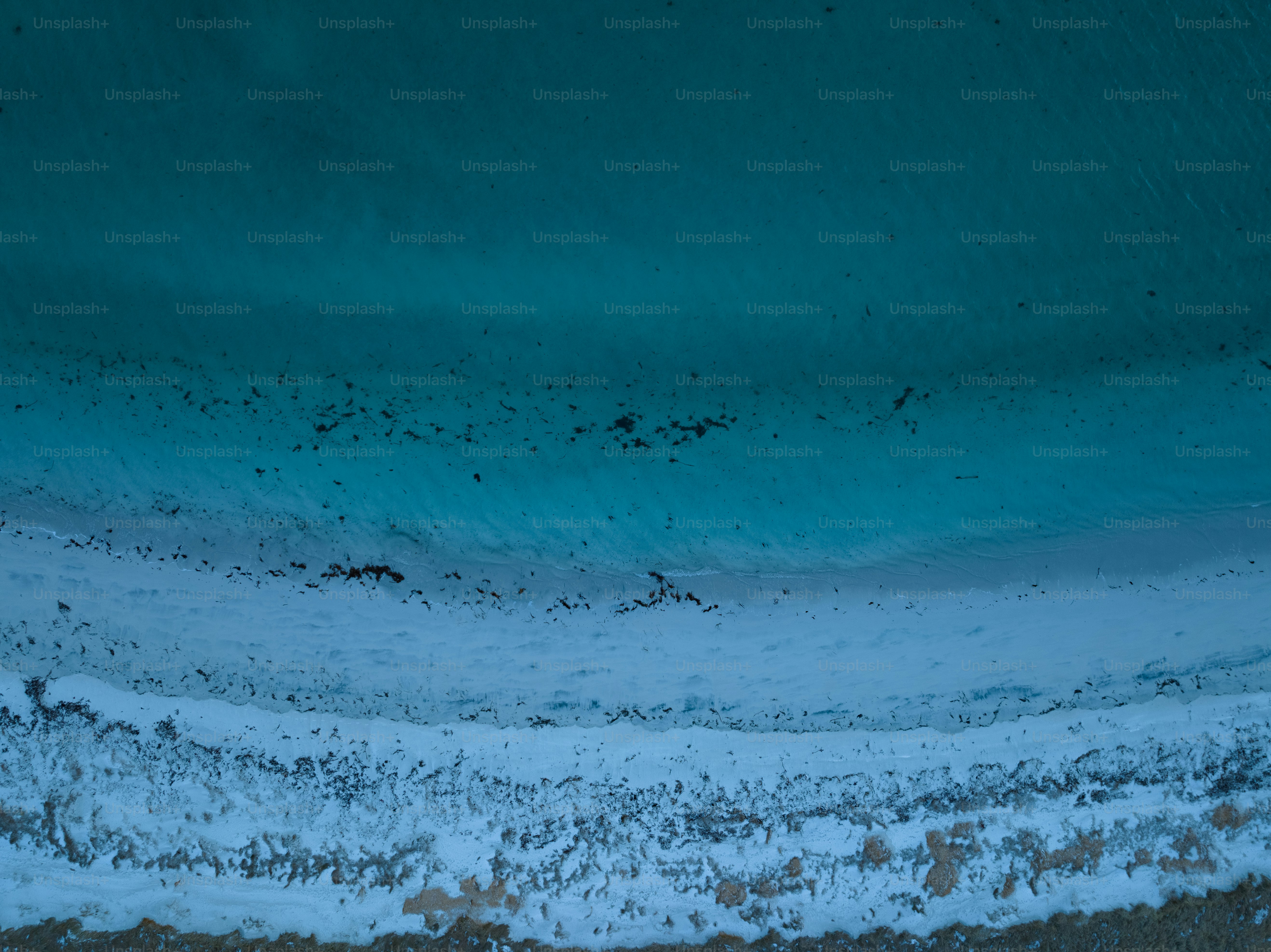 Foto Un camino cubierto de nieve junto a un cuerpo de agua – Mar Imagen ...