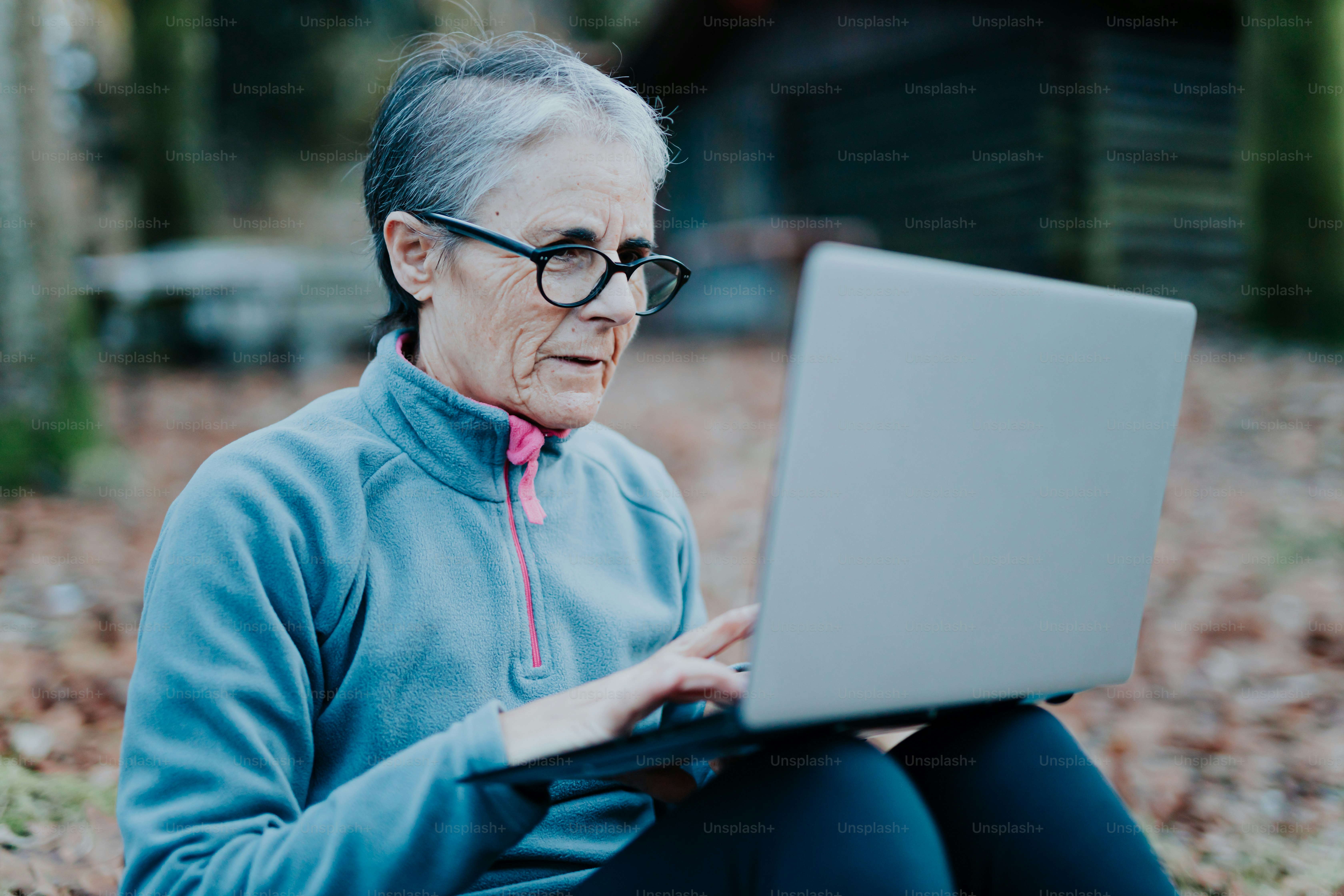 A woman sitting on the ground using a laptop computer photo – Older ...