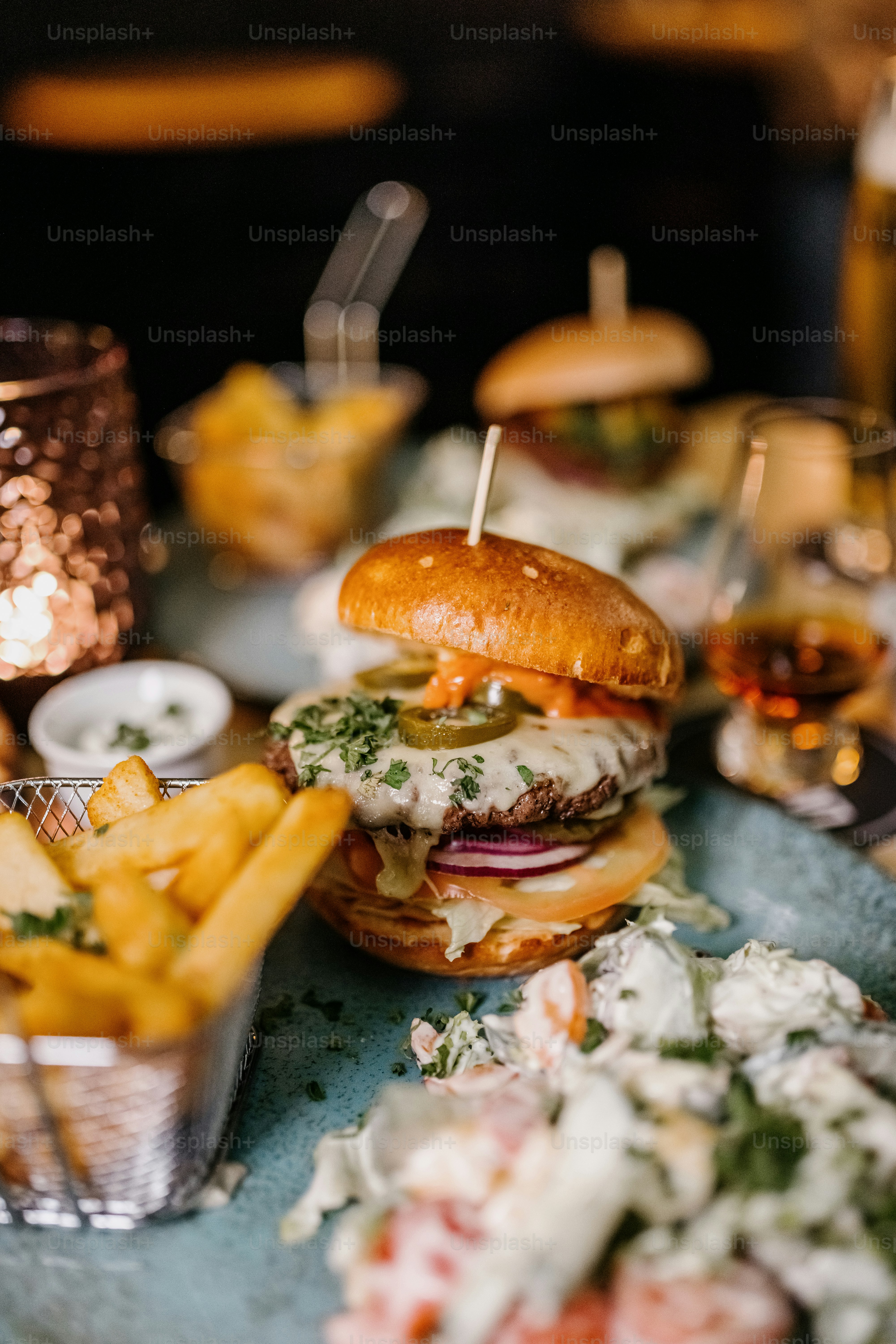 A table topped with burgers and french fries photo – Burger fries Image ...
