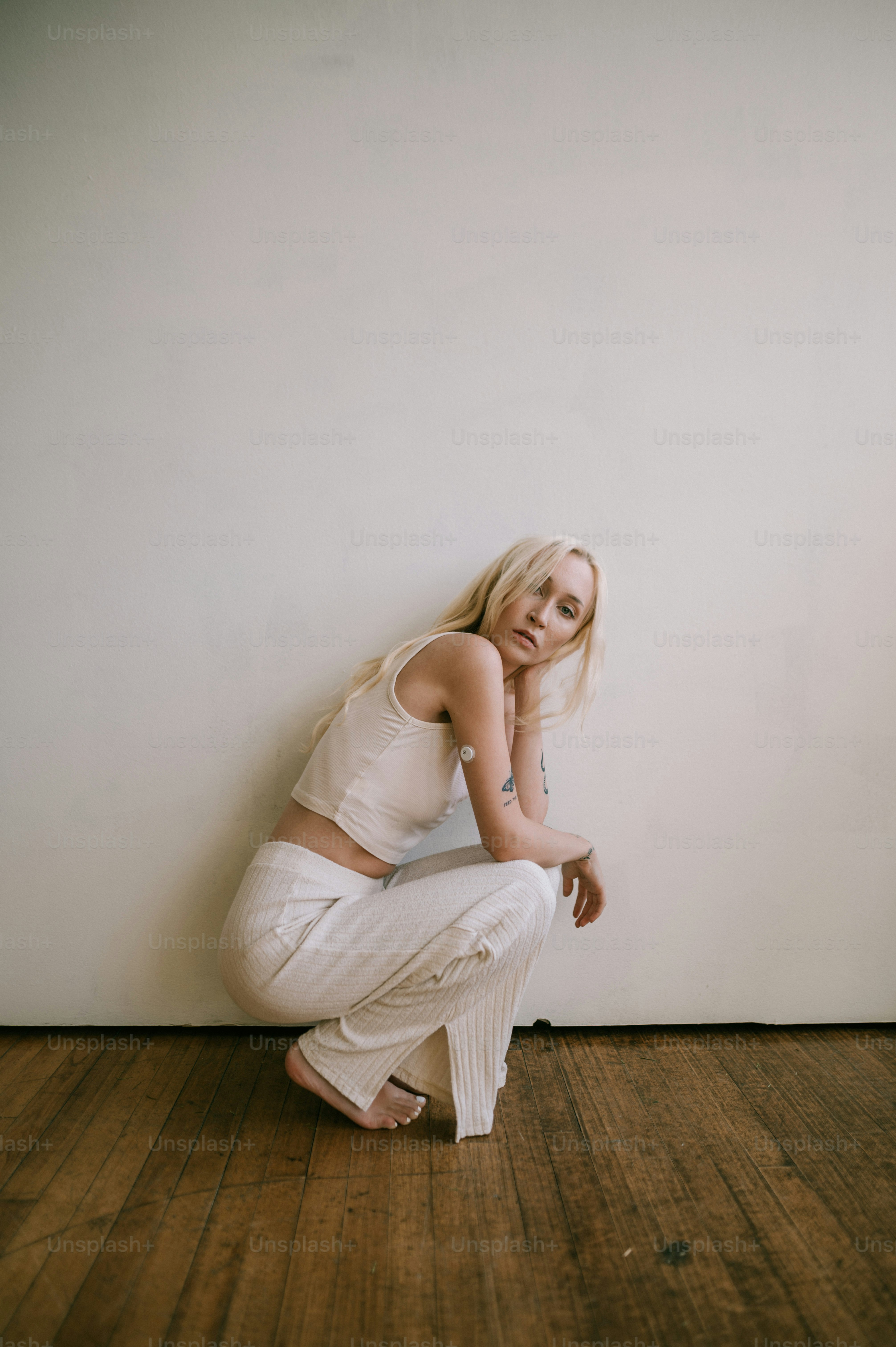 Une femme assise par terre, les mains sur les genoux photo – Femme ...
