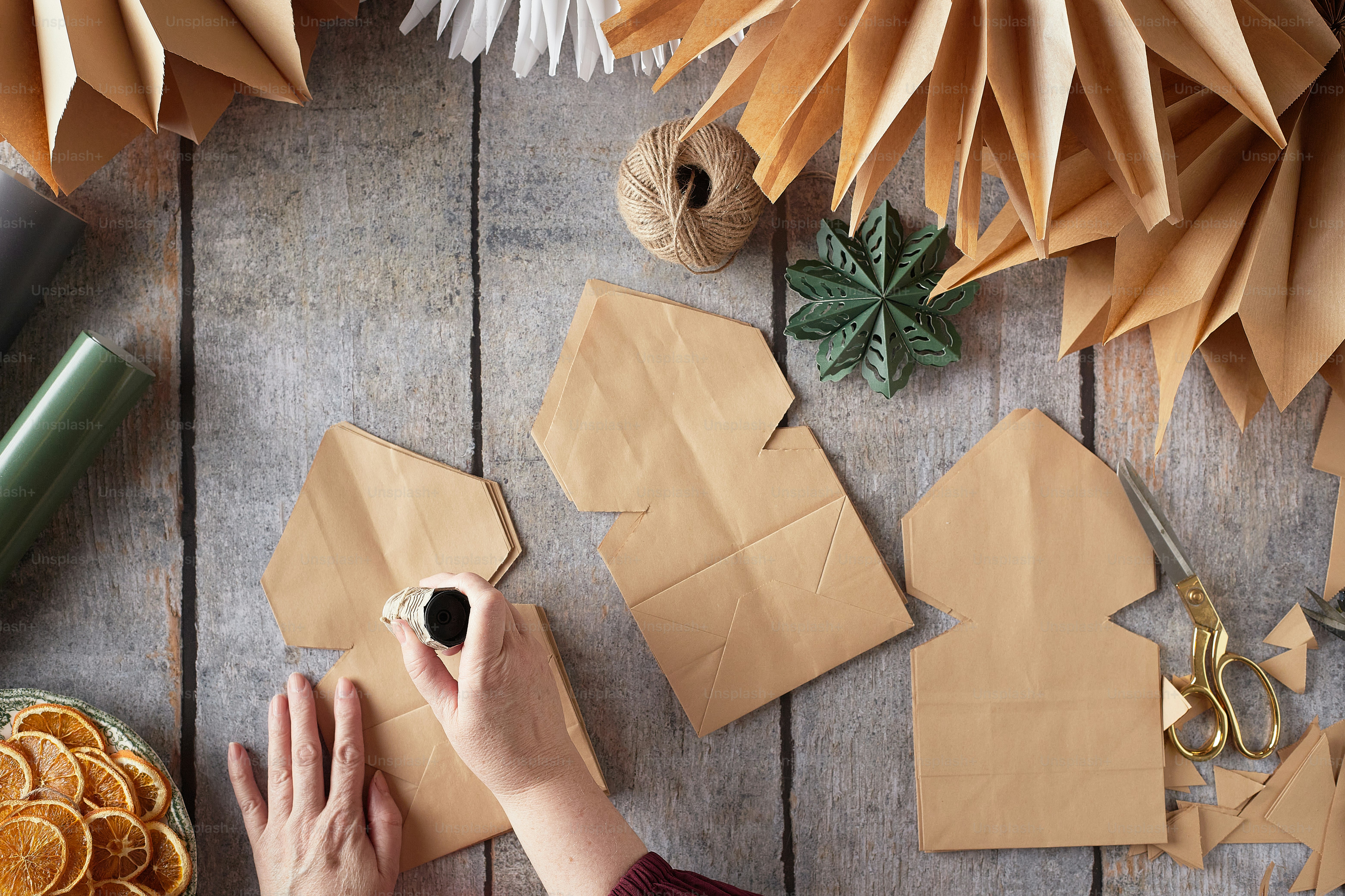 A person is making paper decorations on a table photo – Decor Image on ...