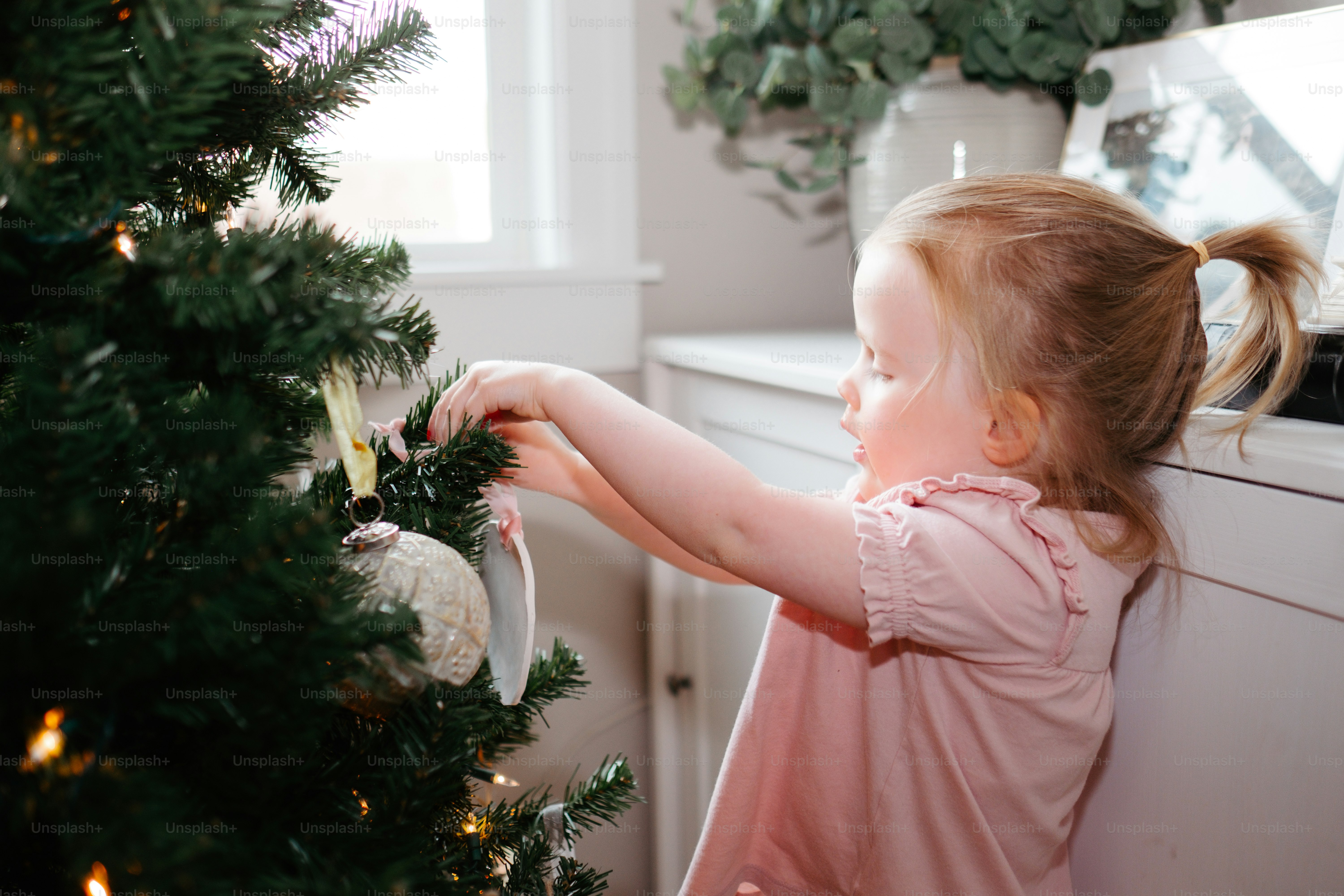 A little girl touching a christmas tree photo – Christmas Image on Unsplash