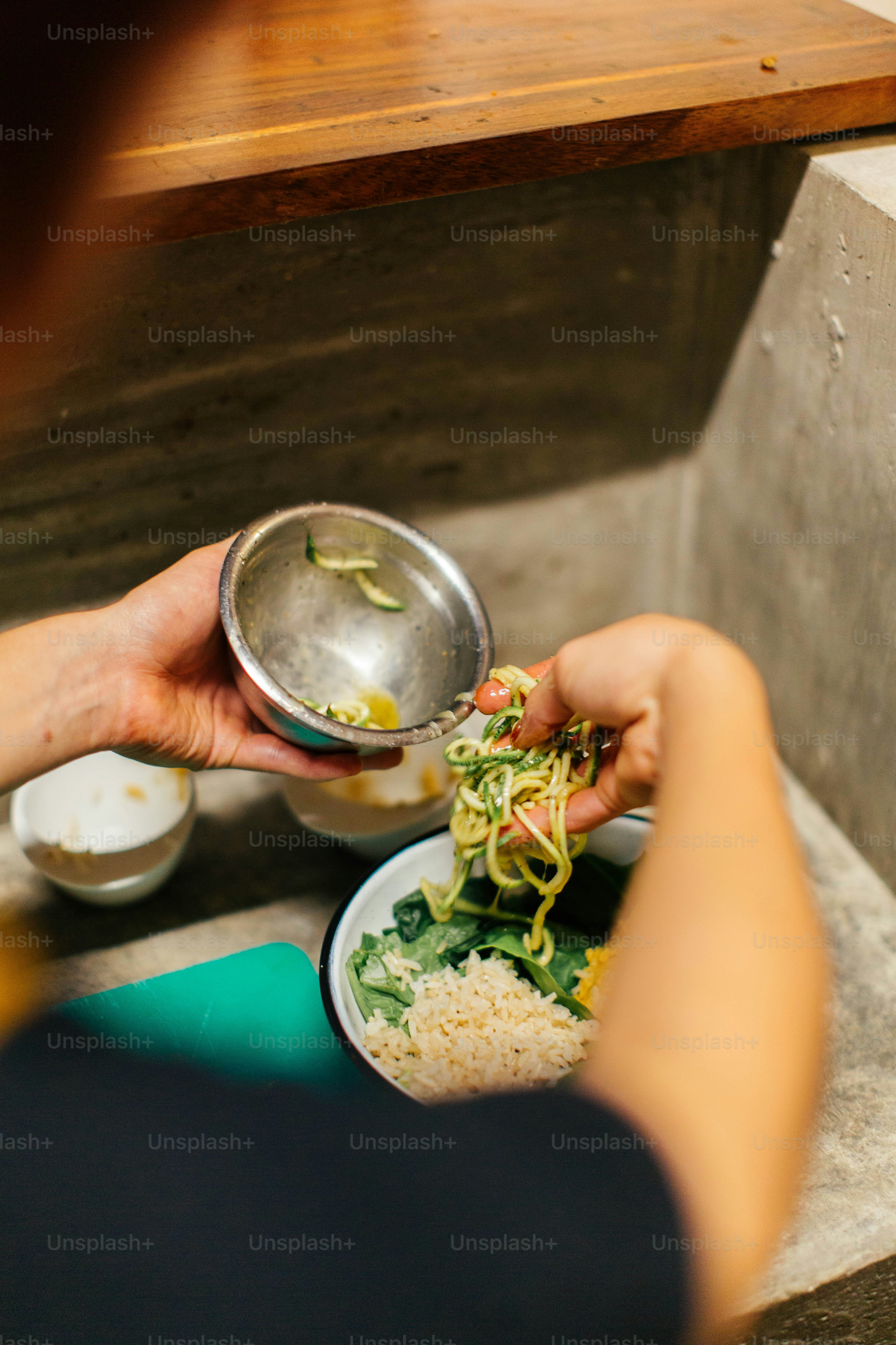 A person holding a spoon over a plate of food photo – Snack bowls Image ...