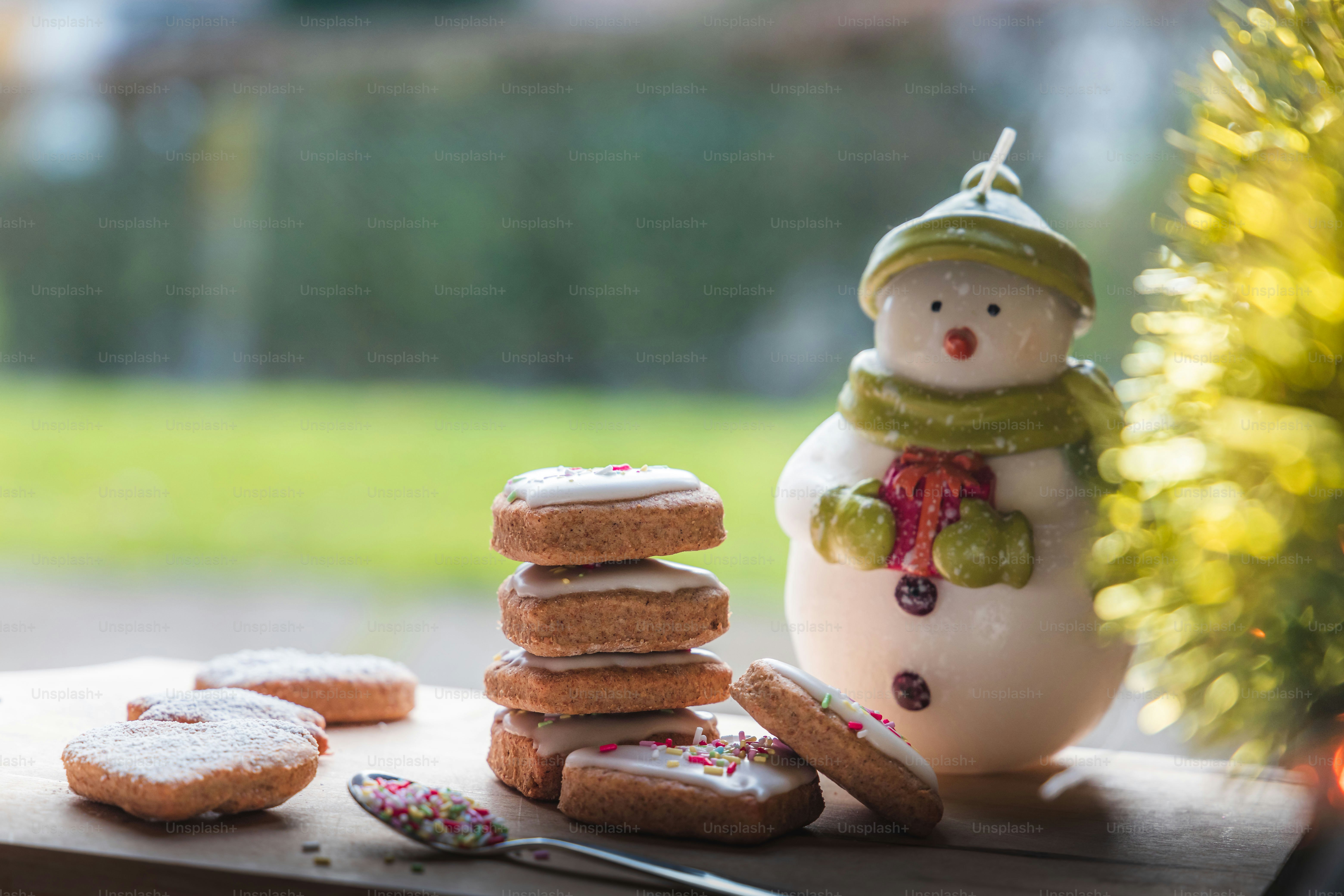 A small figurine next to a pile of cookies photo – Gingerbread biscuits ...