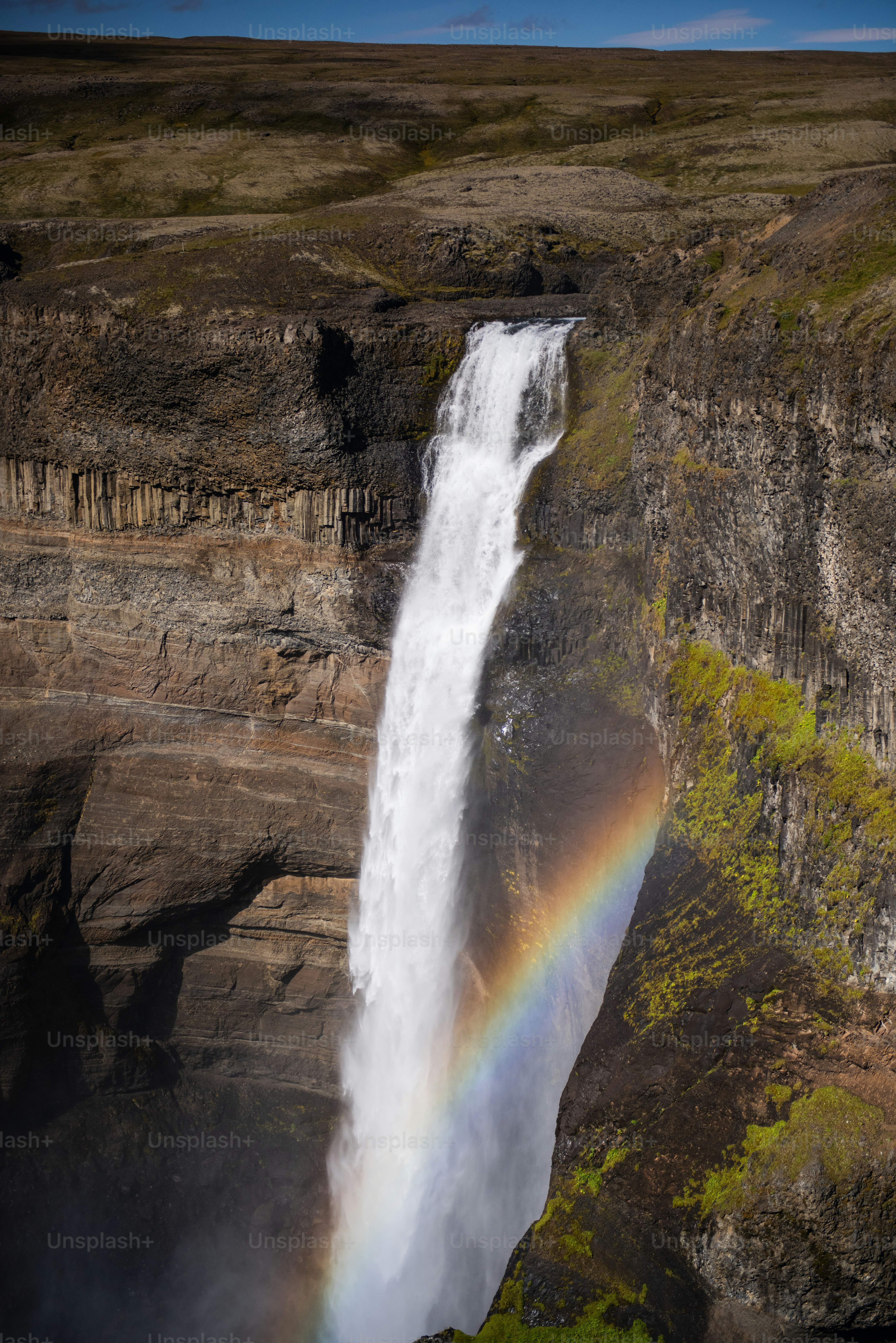 A waterfall in a canyon photo – Mountains Image on Unsplash