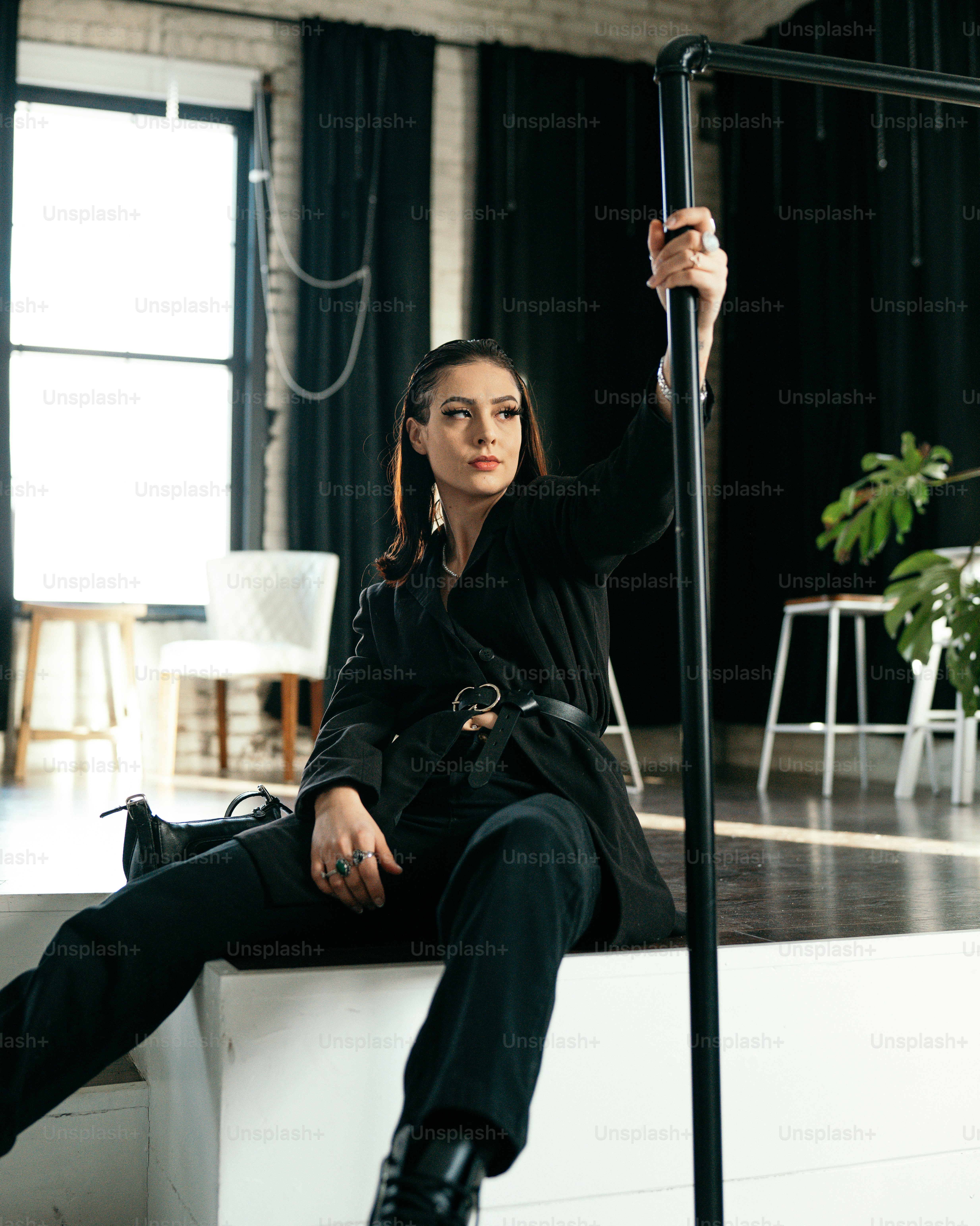 a person sitting on a chair holding a pole photo – Female Image on Unsplash