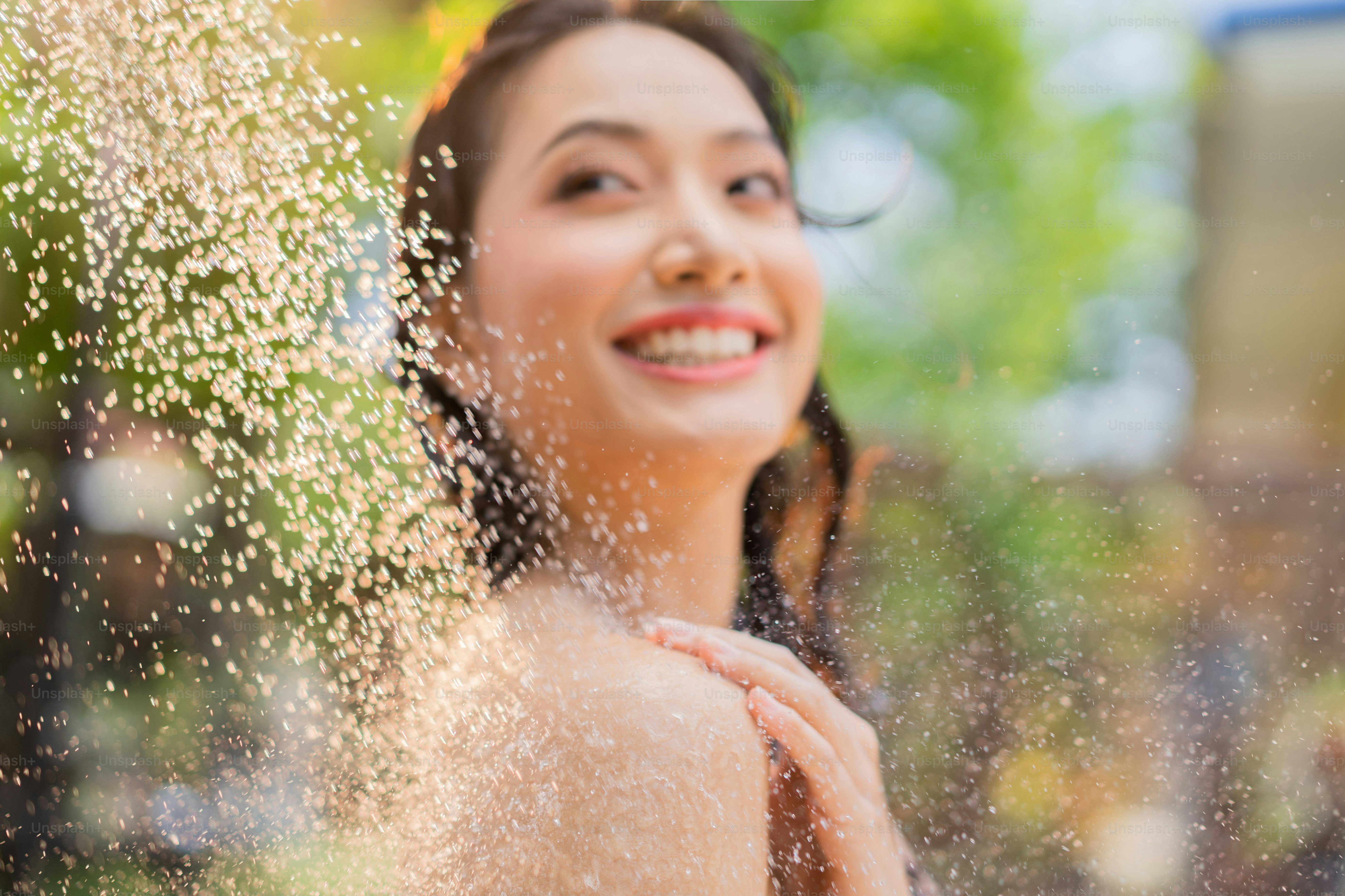 Asian woman, she uses a shower and wash hair outside. She is resting at ...