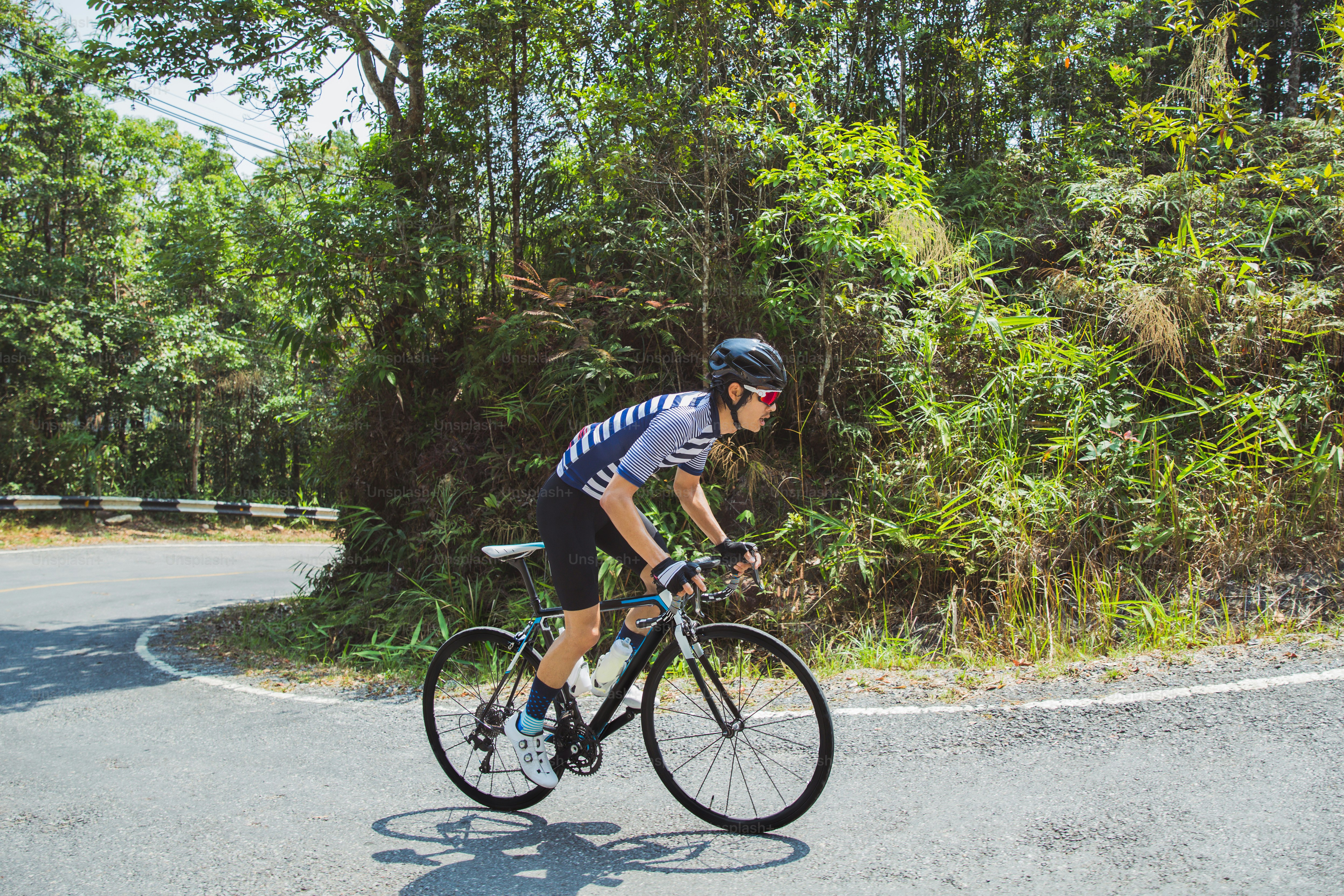 Asian men are cycling road bike in the morning.He is on a forest road ...