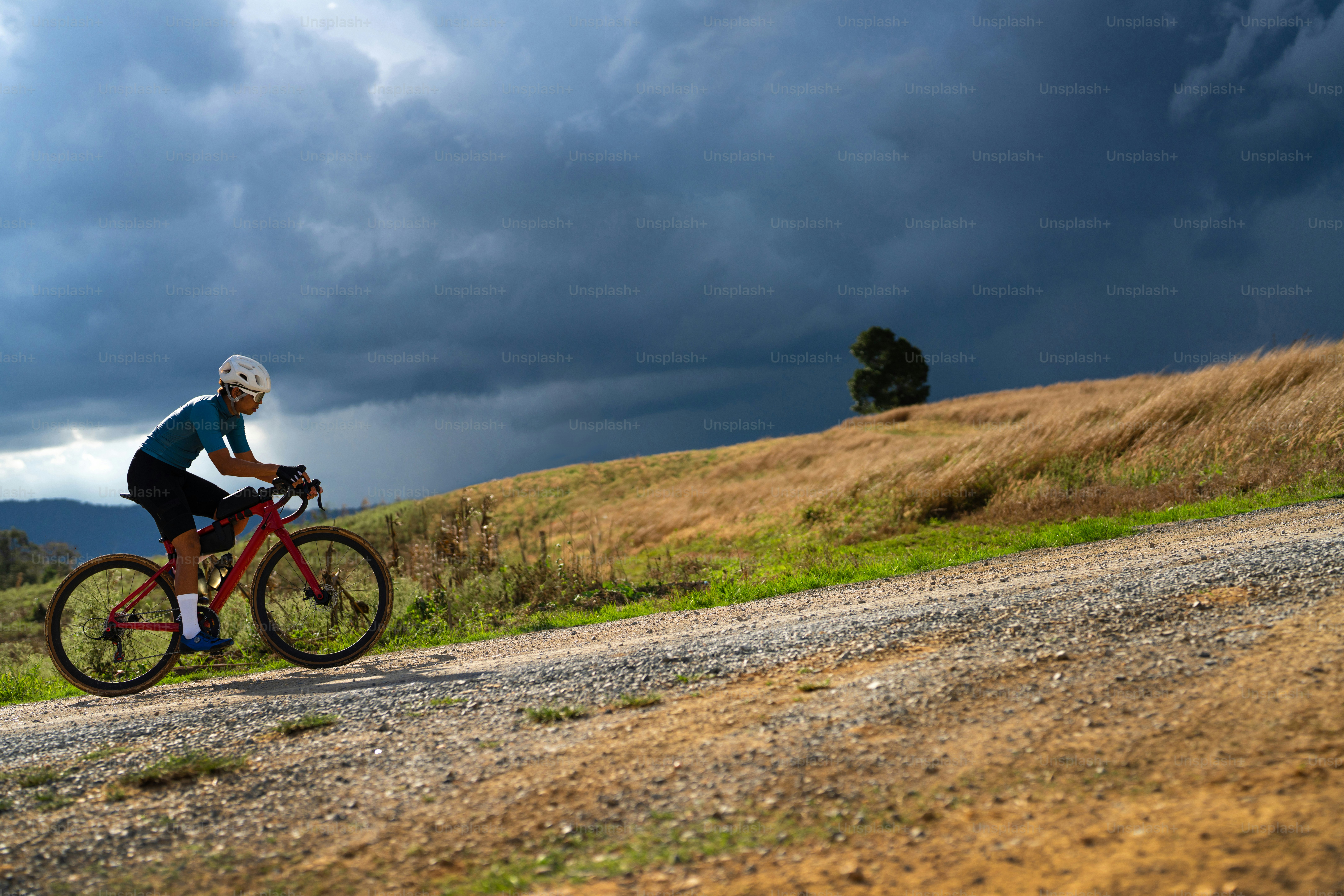 Cyclists practicing on gravel roads in bad weather day photo – Mountain ...