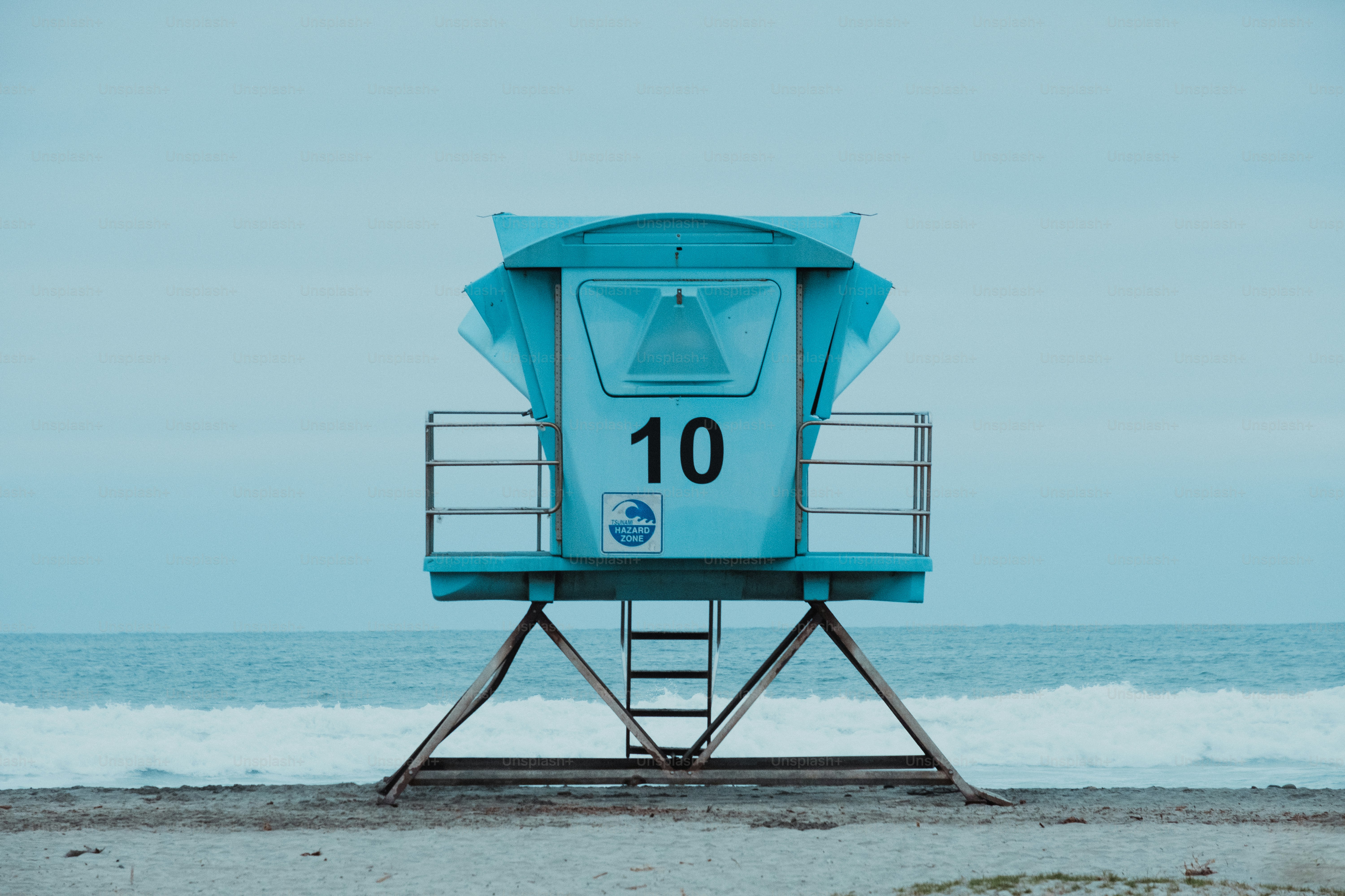 A blue and white water tower on a beach photo – Beach Image on Unsplash
