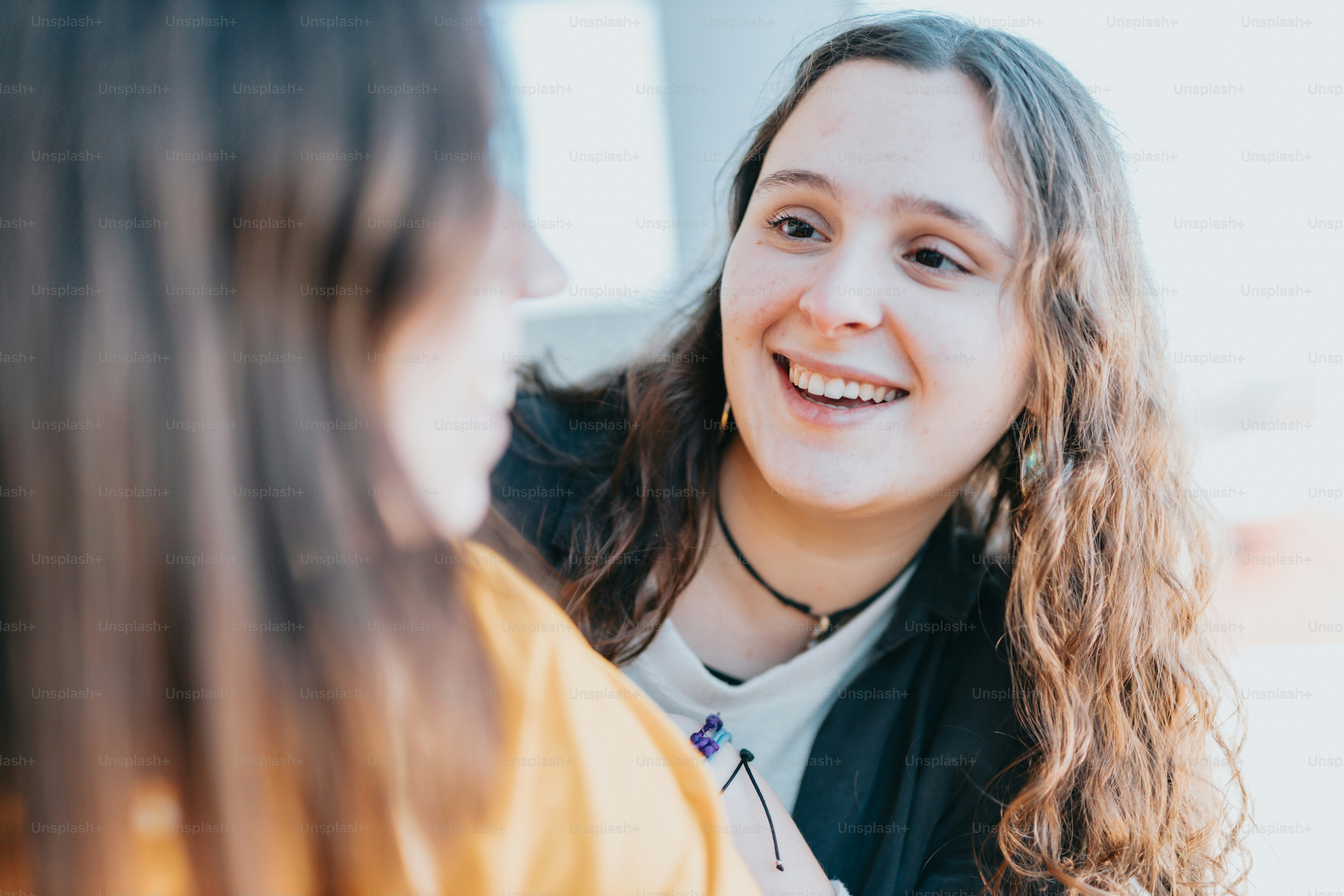 A woman smiling at another woman photo – People Image on Unsplash