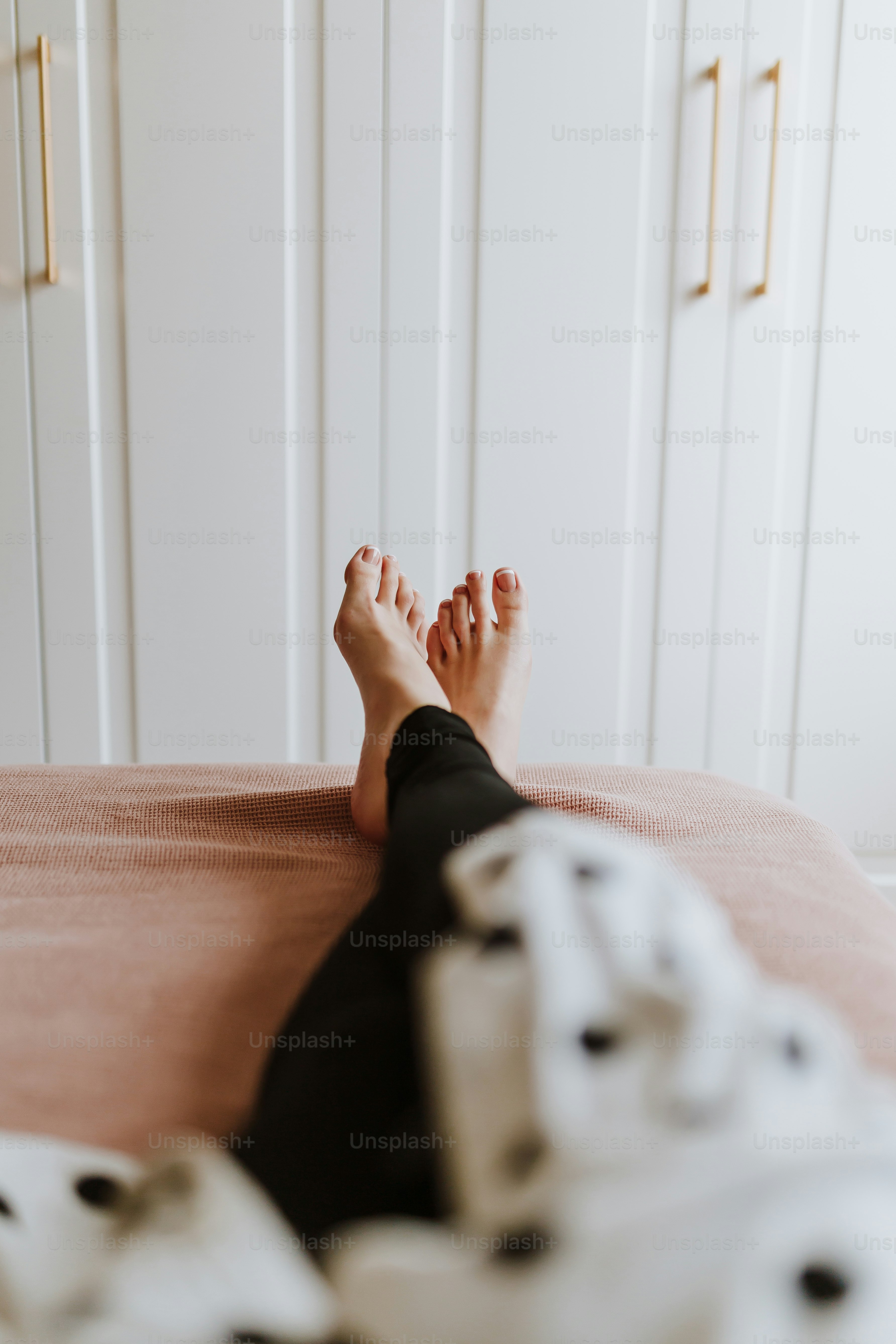 Una persona acostada en una cama con los pies en alto foto – Imagen de ...