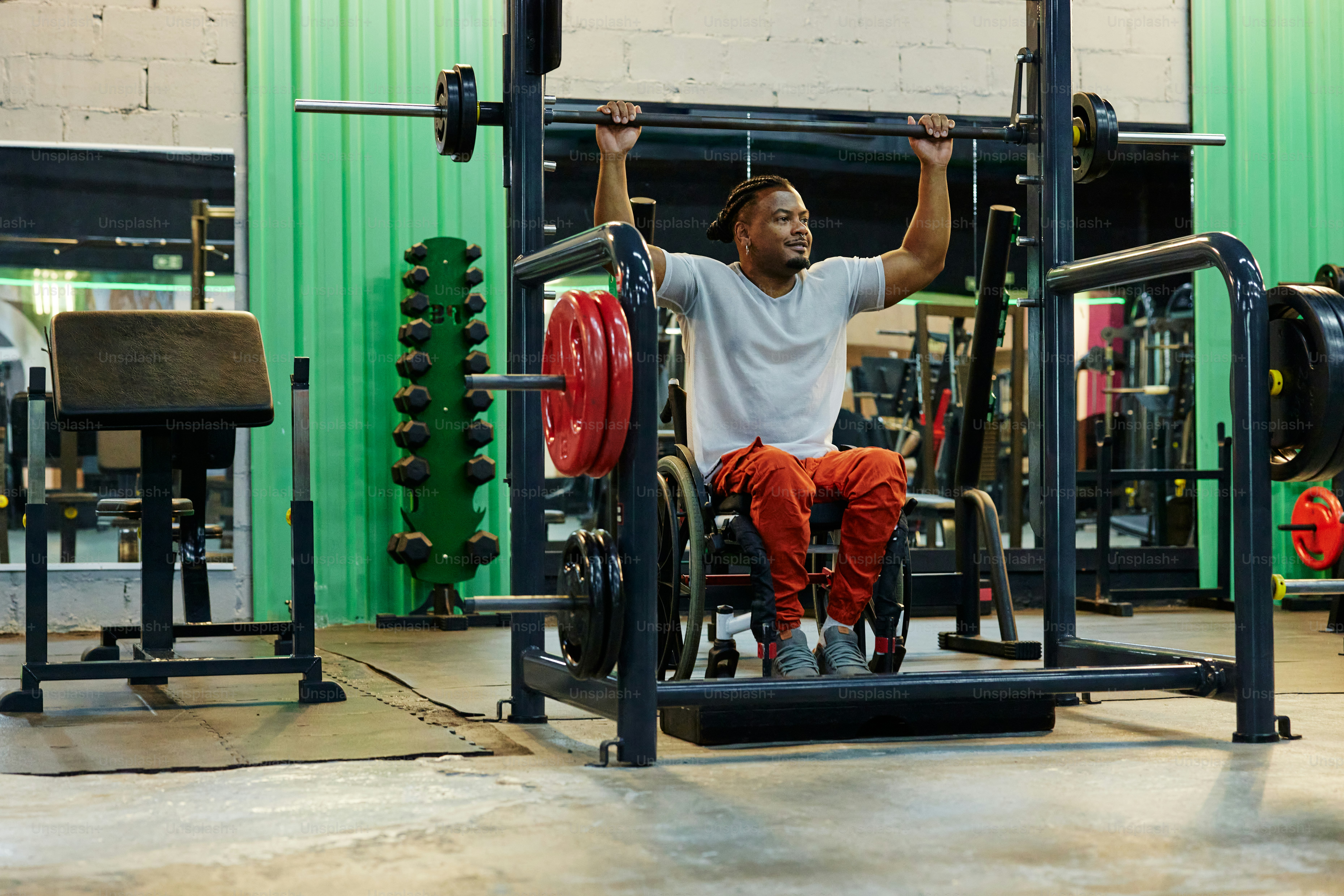 A man squats on a bench in a gym photo – Working out Image on Unsplash