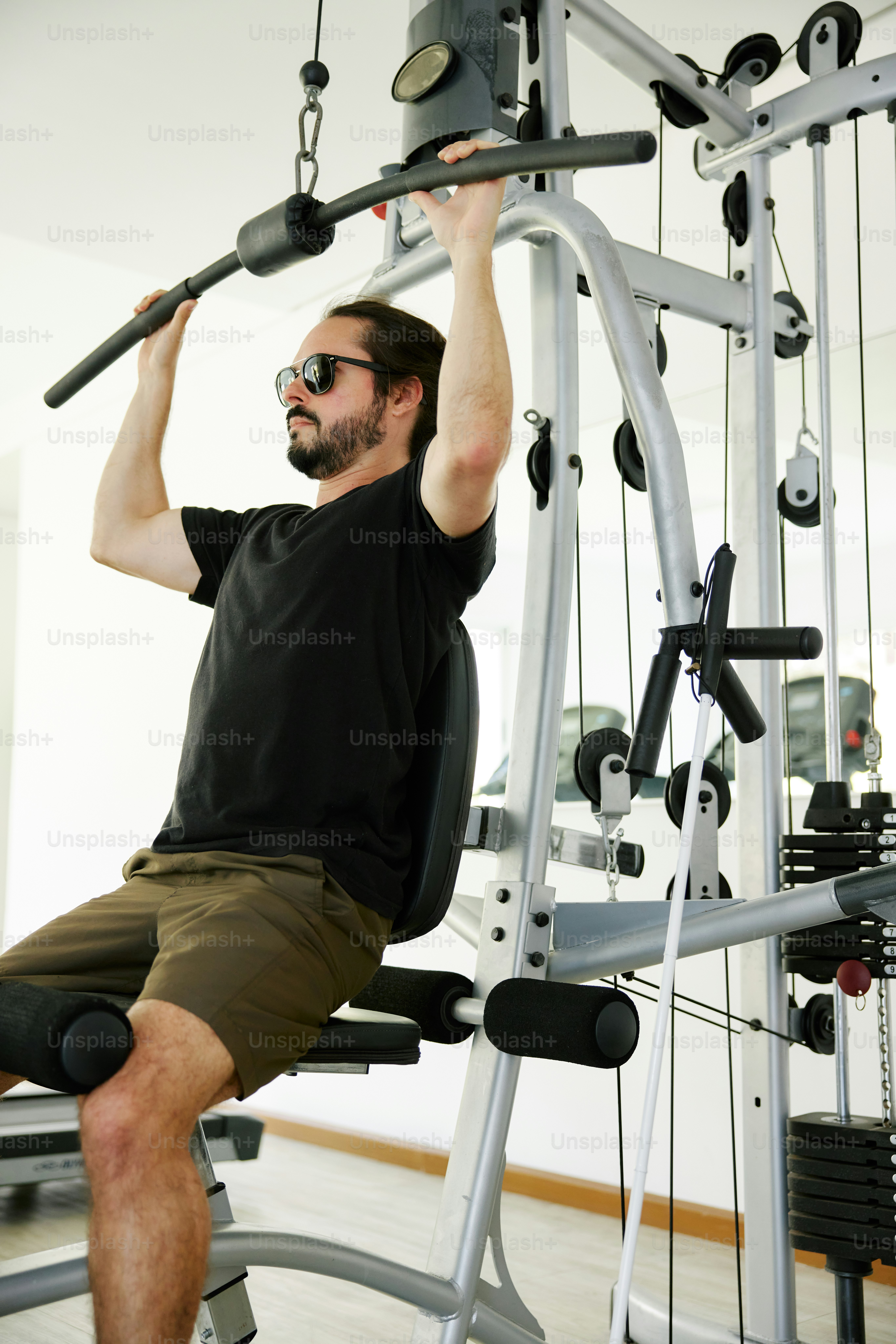 Un homme assis sur un banc dans un gymnase photo – S'entraîner Photo ...