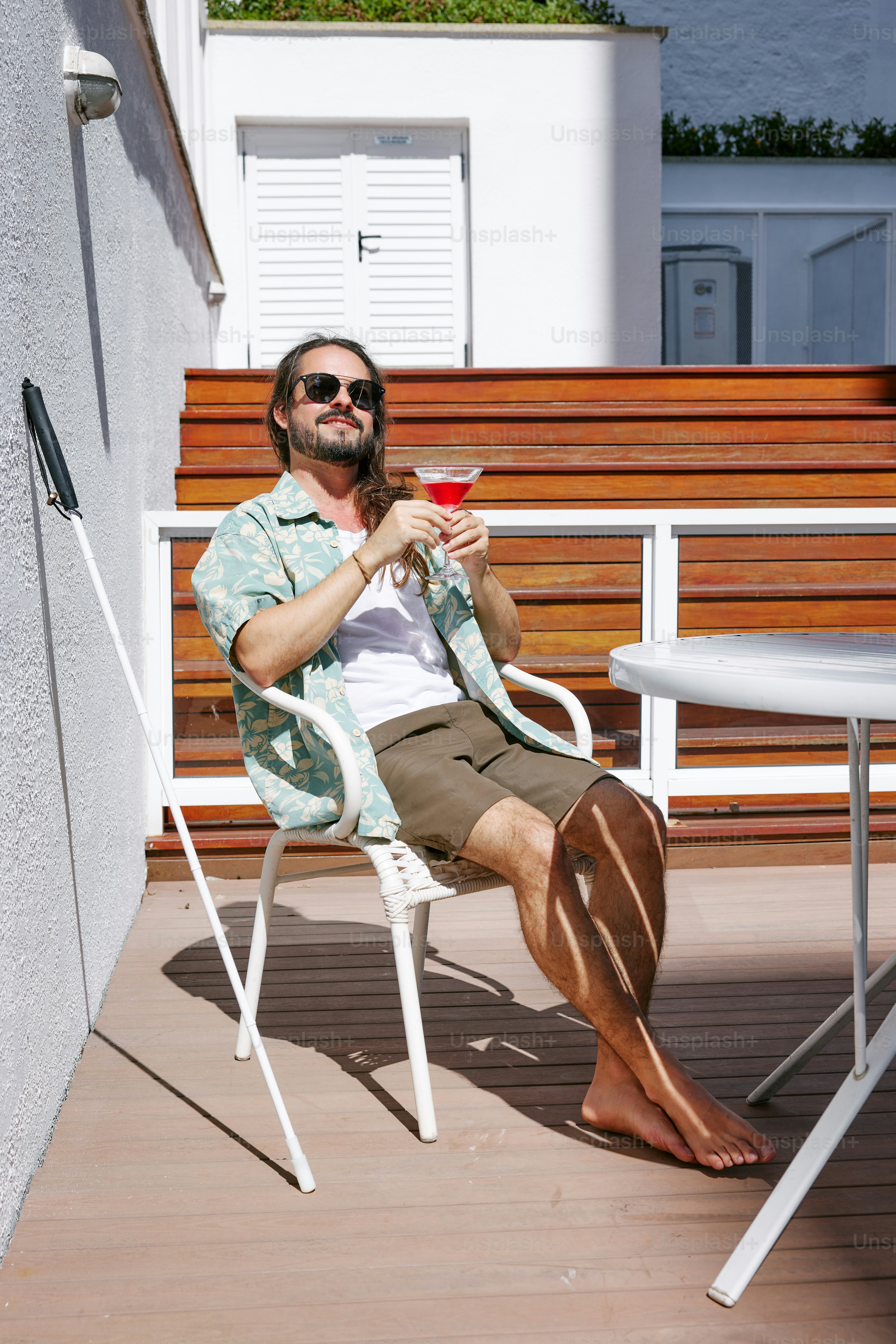 Un homme assis sur une chaise blanche à côté d’une table photo ...