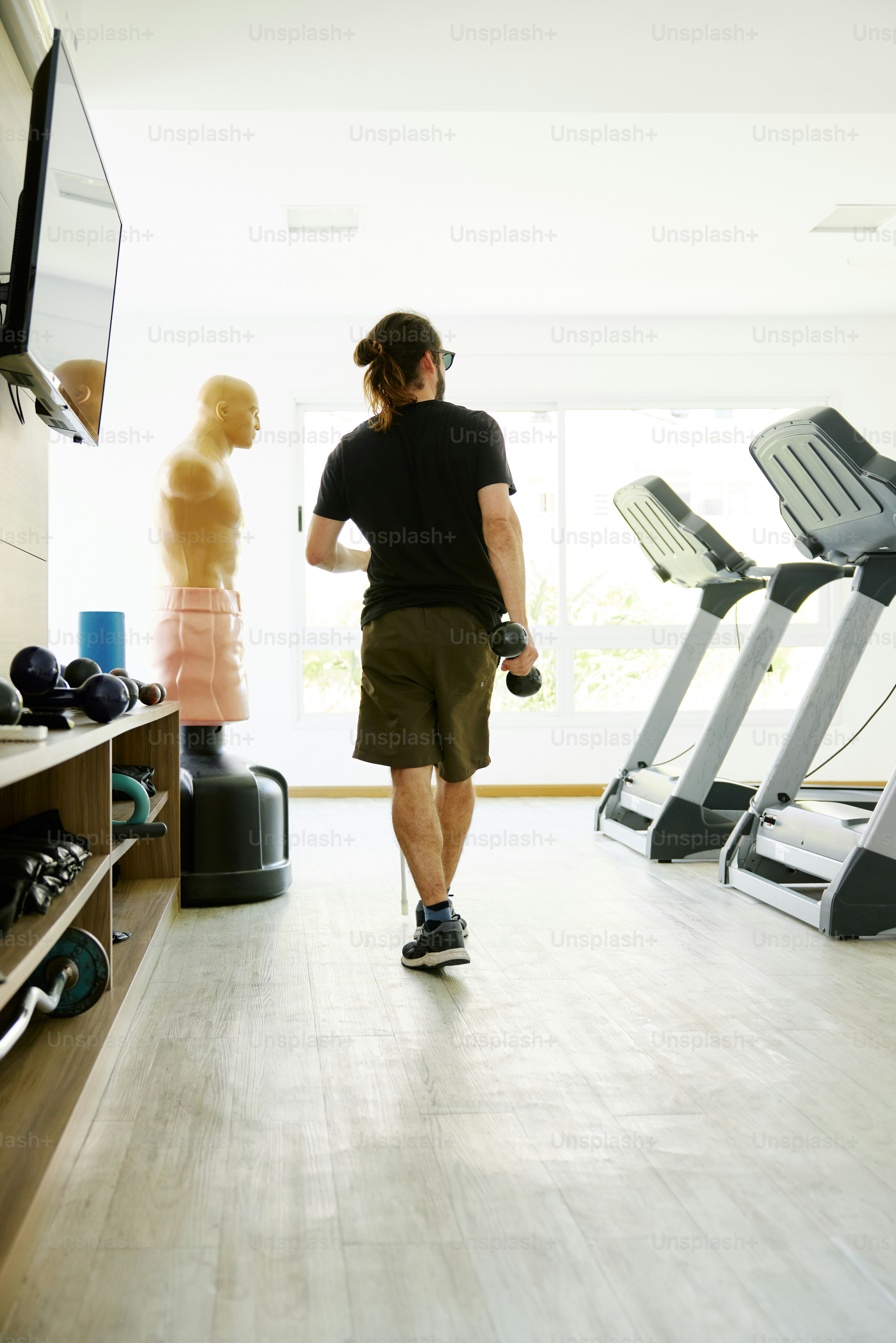 A man is walking in a room with treadmills photo – Working out Image on ...