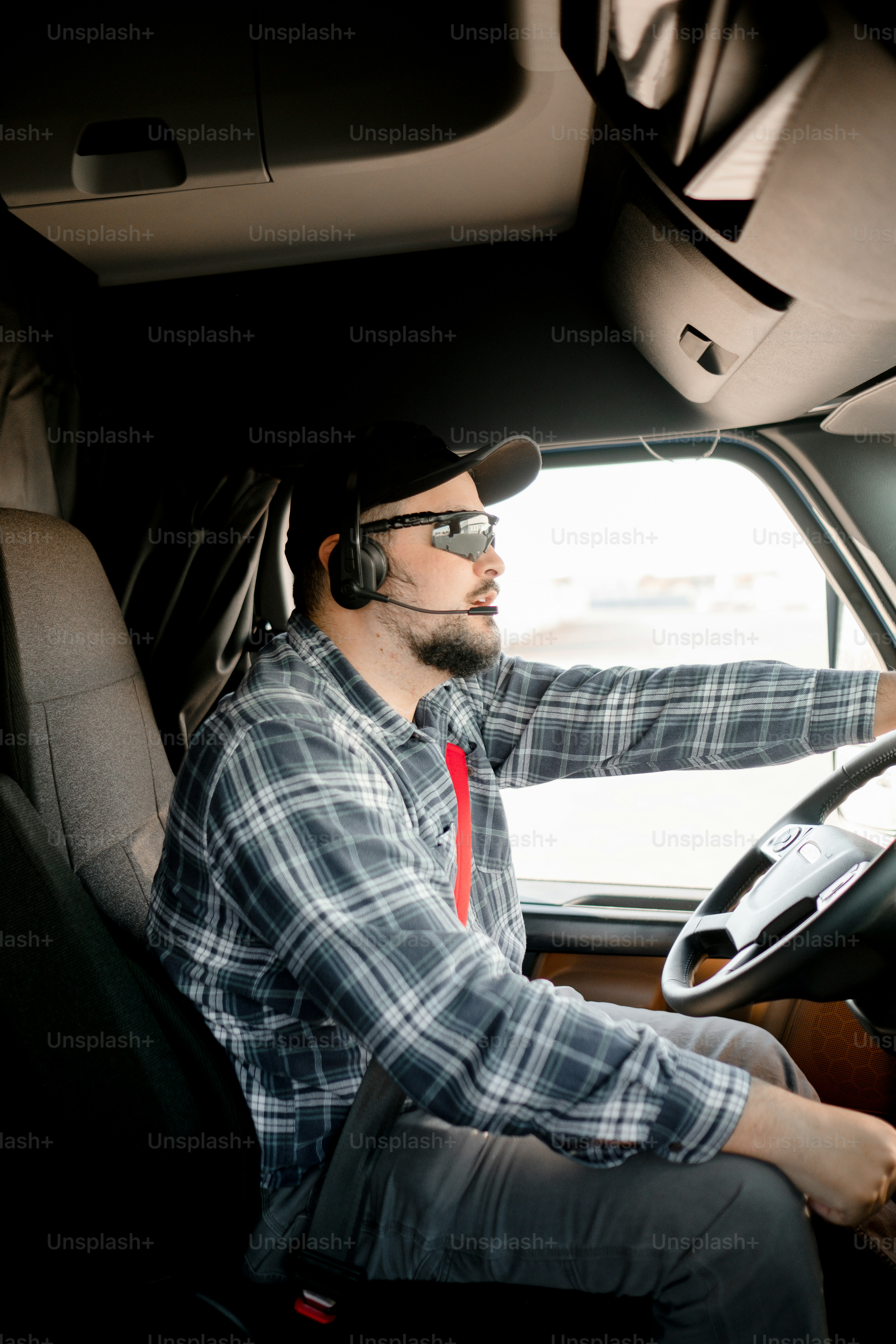 A man driving a truck wearing a headset photo – Trucker Image on Unsplash