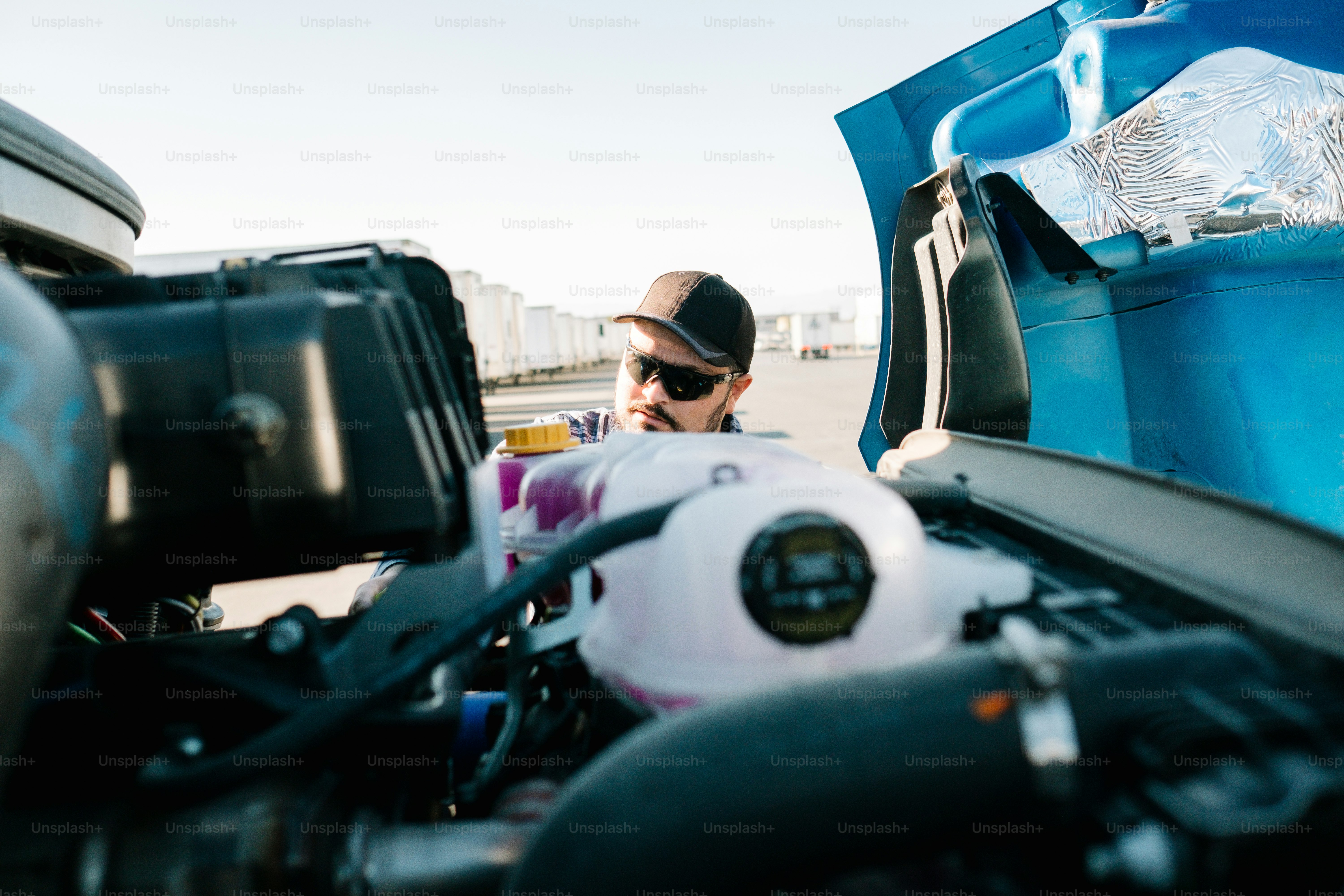 A man sitting in the drivers seat of a truck photo – Trucker Image on ...