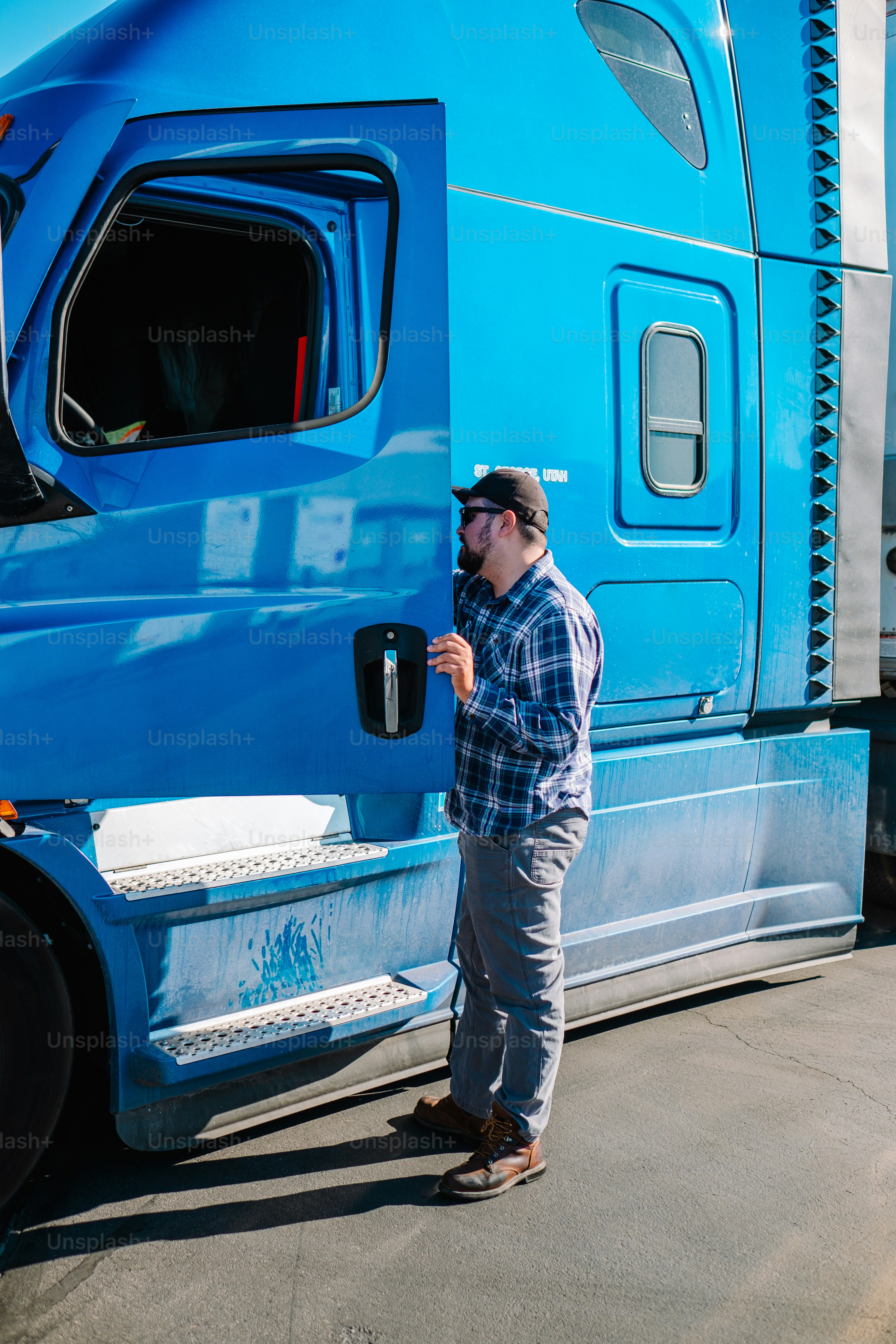 A man standing next to a blue semi truck photo – Trucker Image on Unsplash
