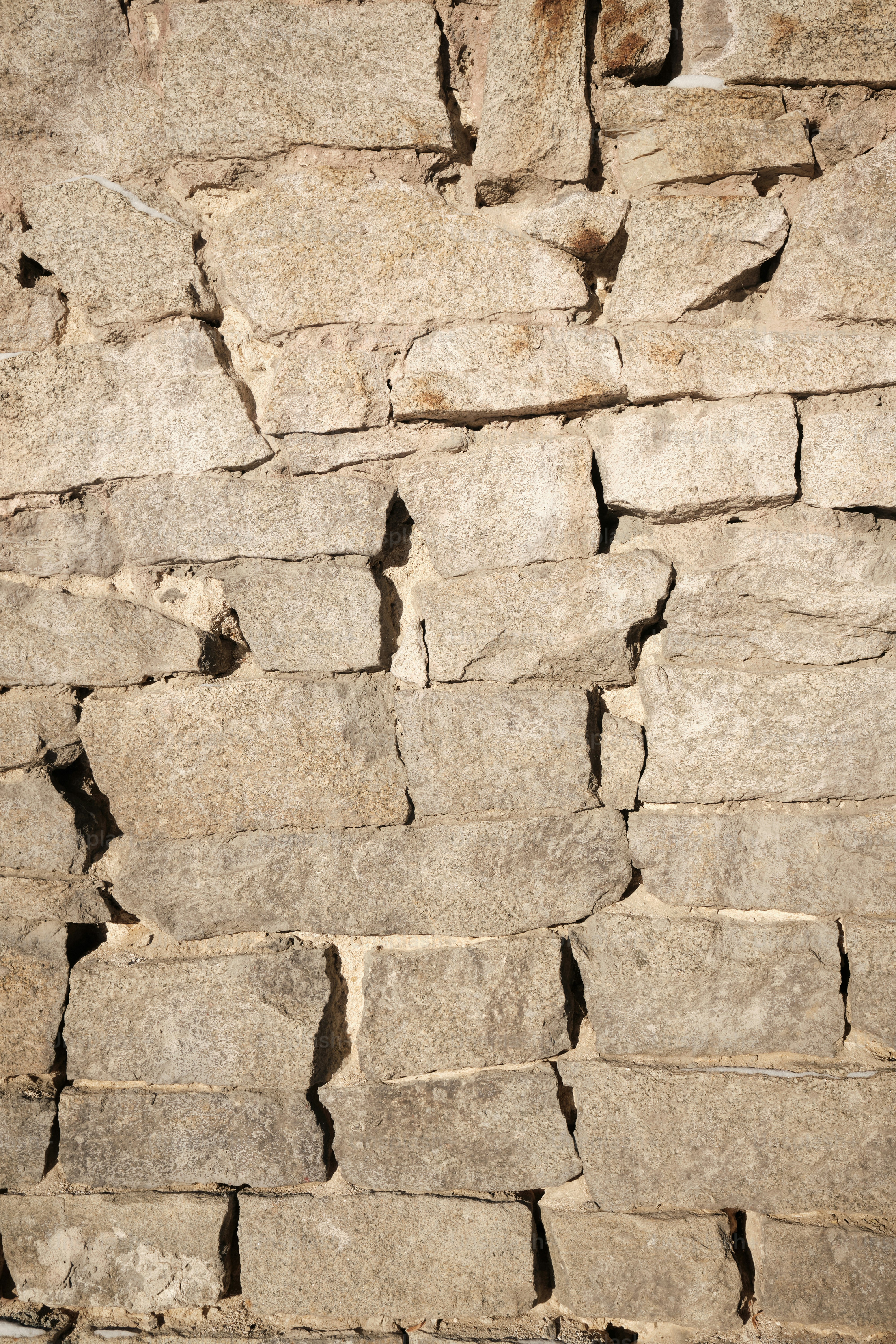 A stone wall with cracks in it photo – Wall background Image on Unsplash