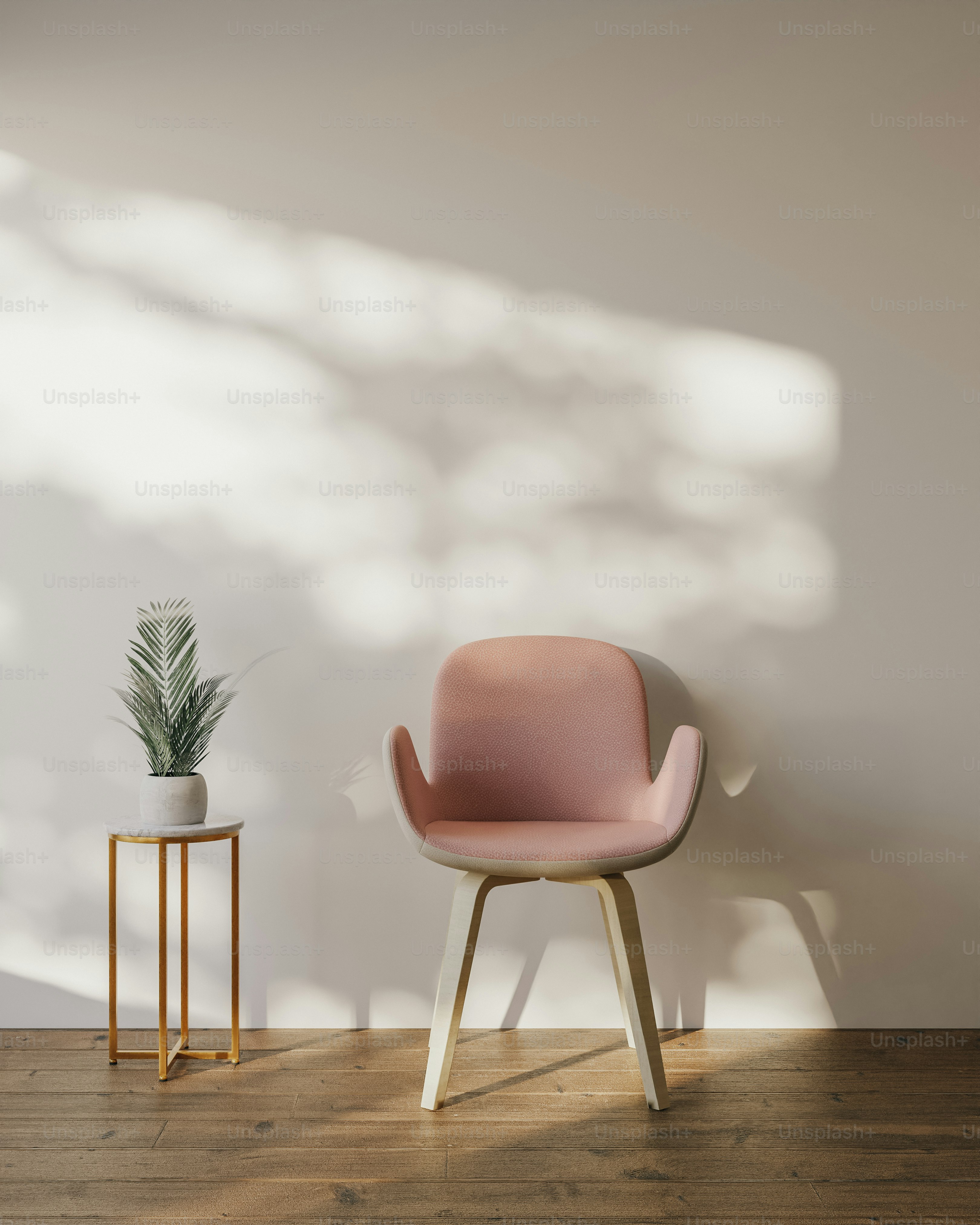 Una silla rosa junto a una pequeña mesa con una planta en maceta foto ...
