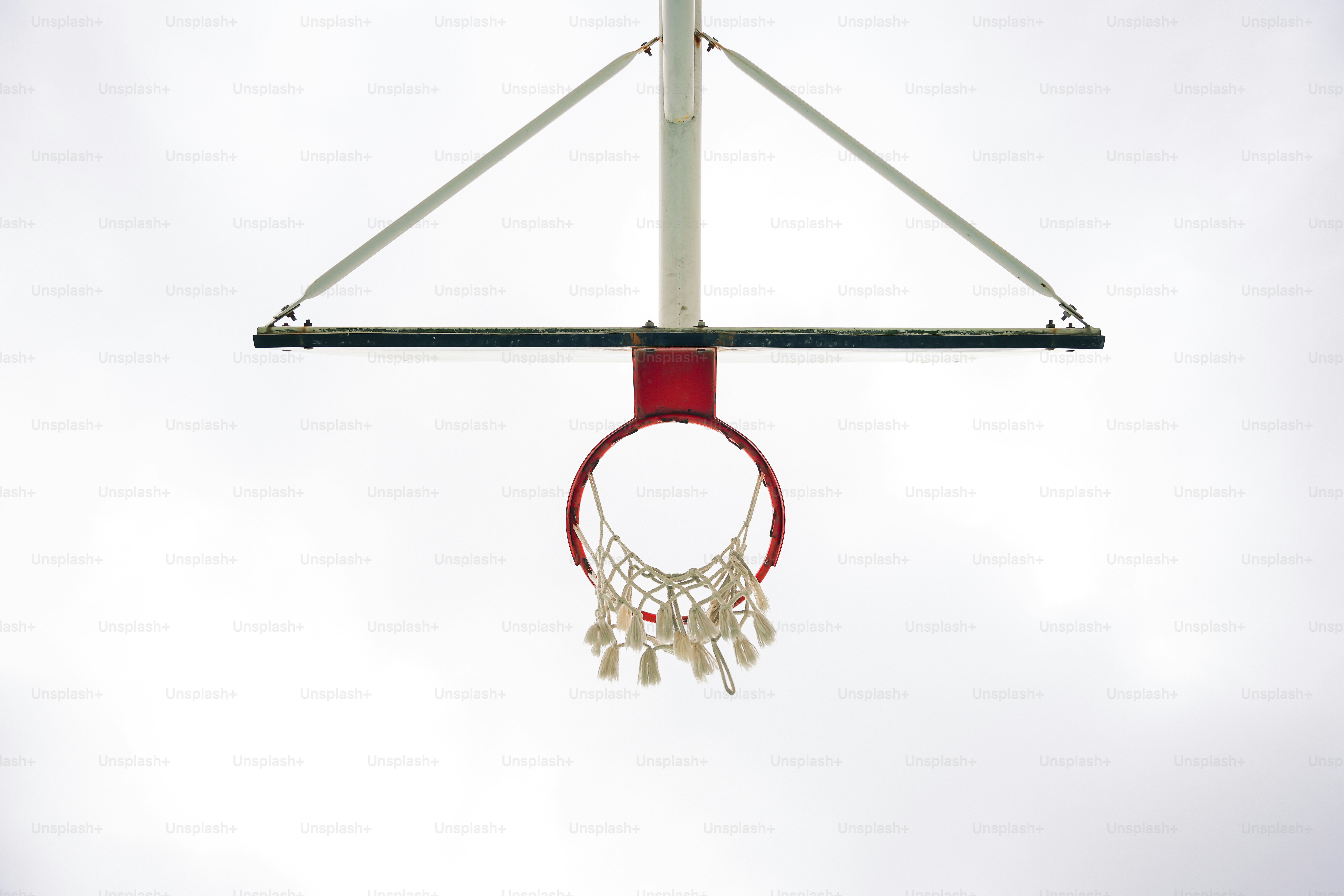 A basketball hoop with a basketball hanging from it photo – Shooting ...