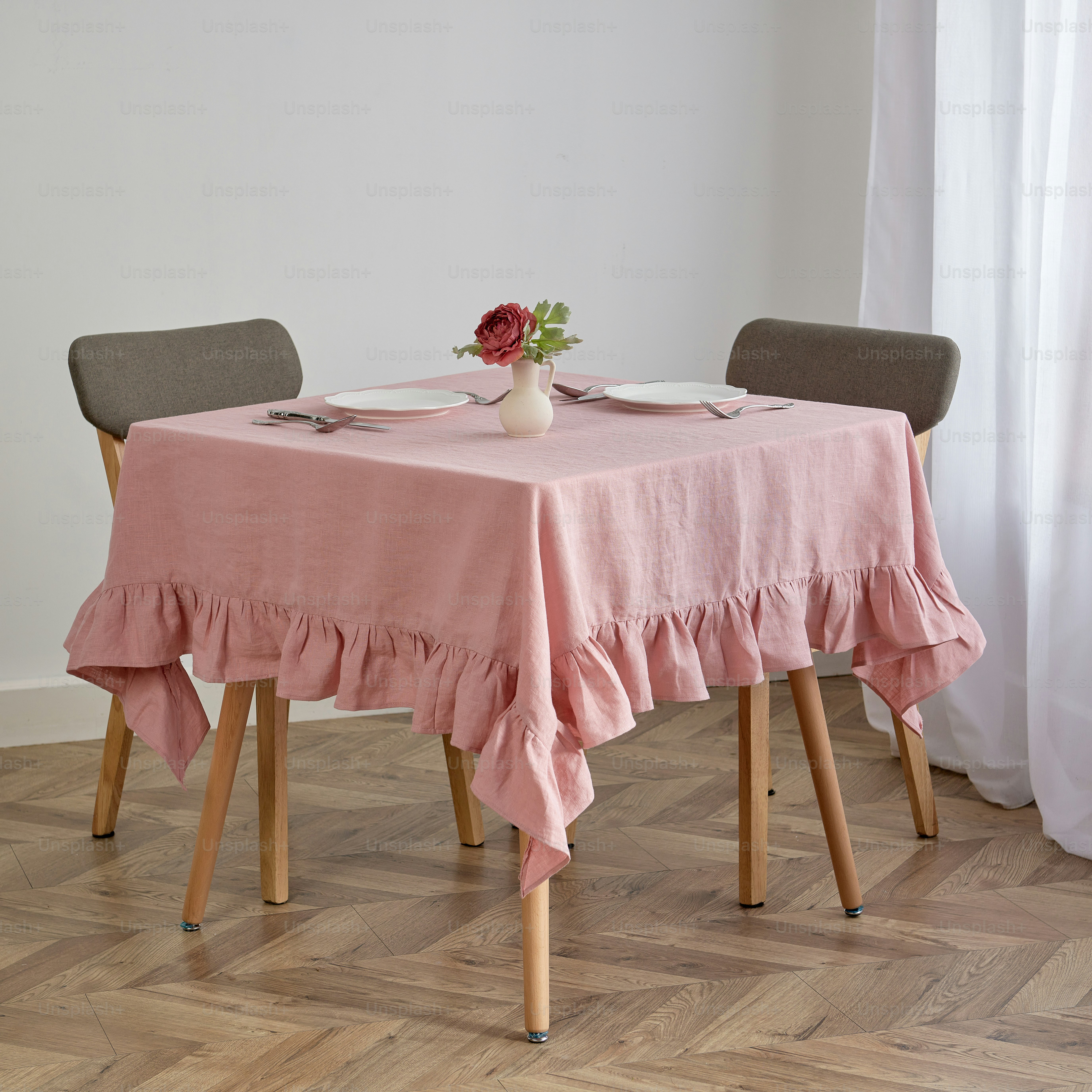 Foto Una mesa con un mantel rosa y un jarrón de flores – Mesa Imagen en ...