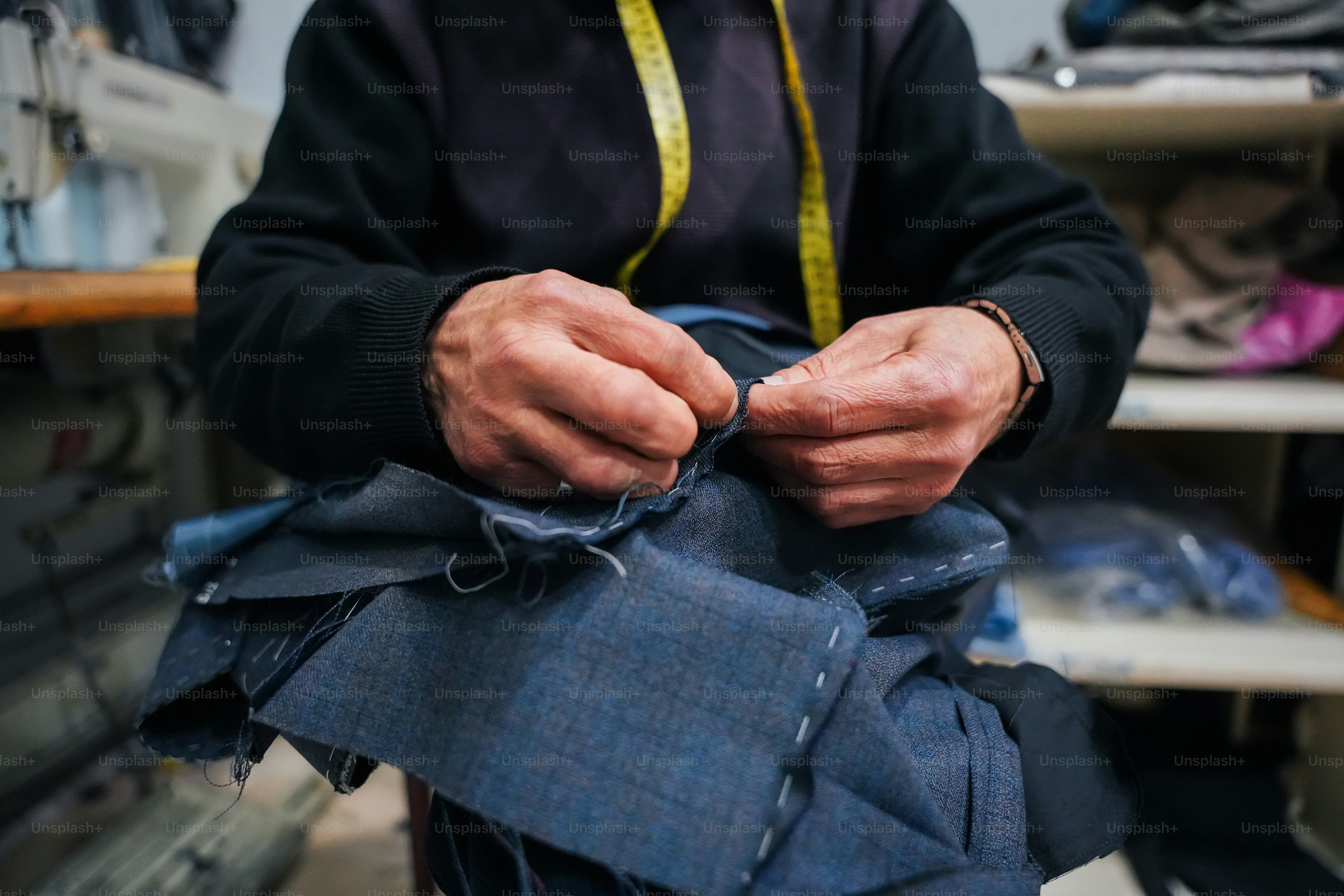 A person holding a piece of cloth in their hands photo – Tailoring ...