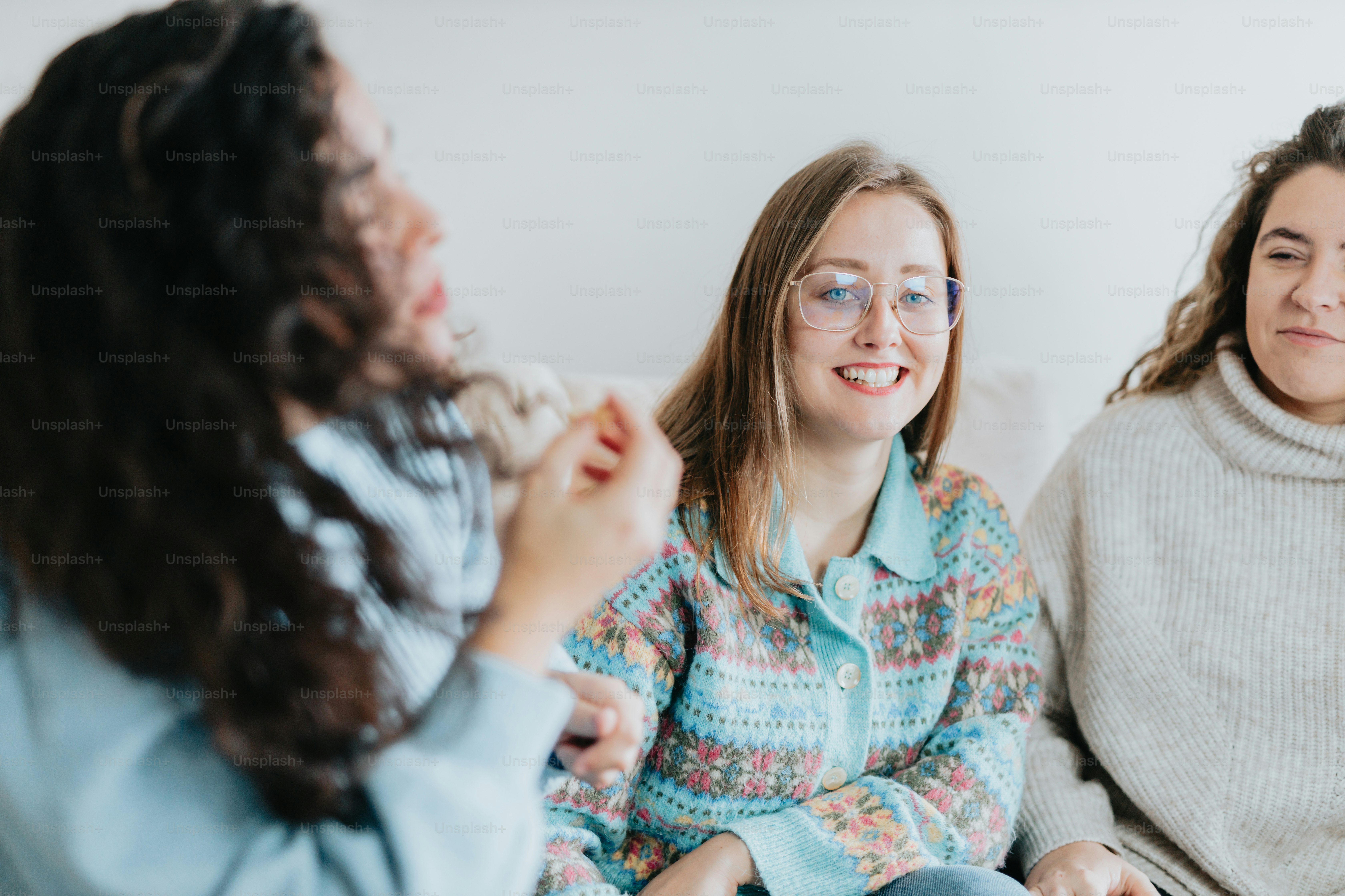 Two women are sitting on a couch and one is brushing her teeth photo ...