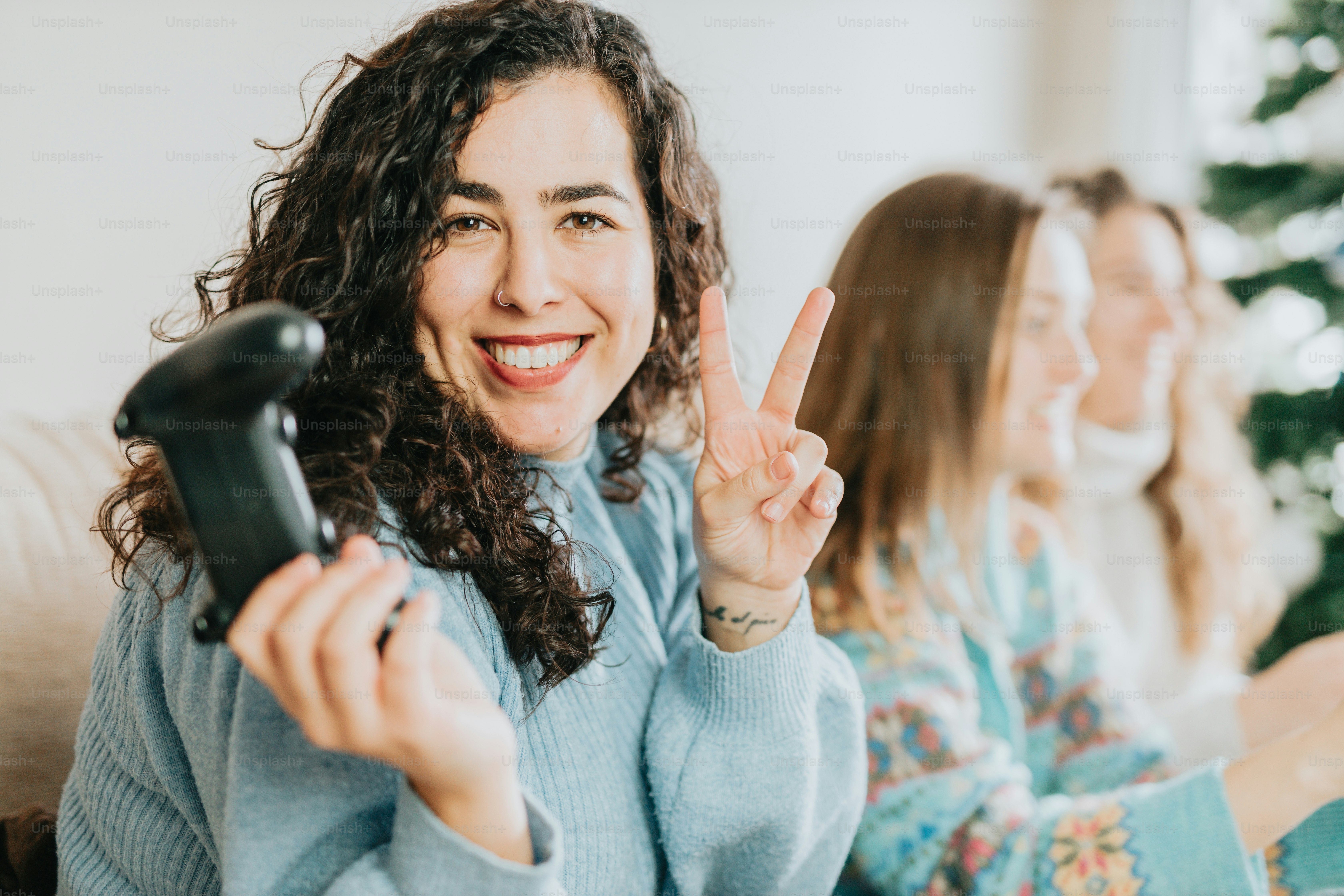 A woman sitting on a couch holding a remote control photo – Smile Image ...