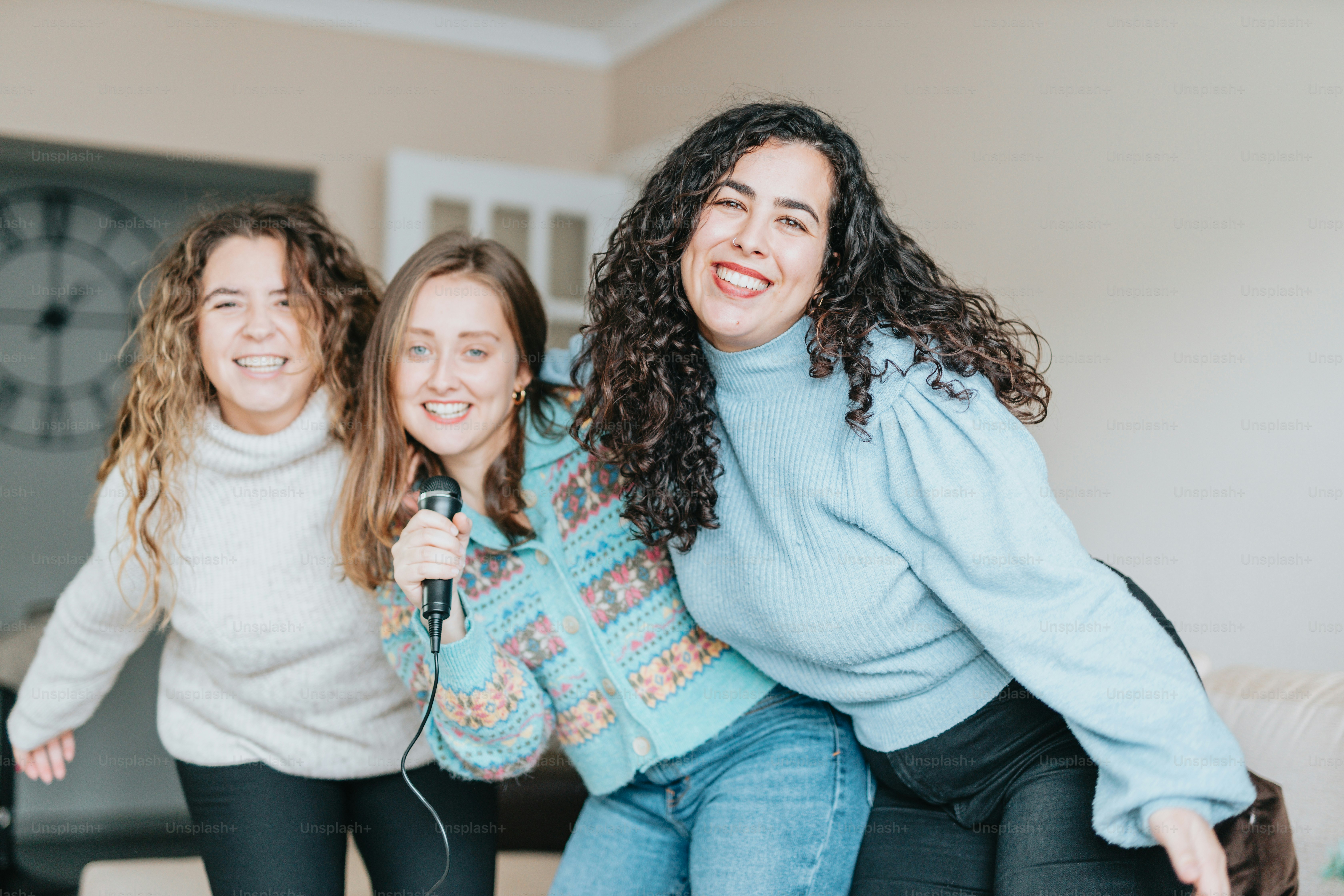 Three women singing into a microphone in a living room photo – Karaoke ...