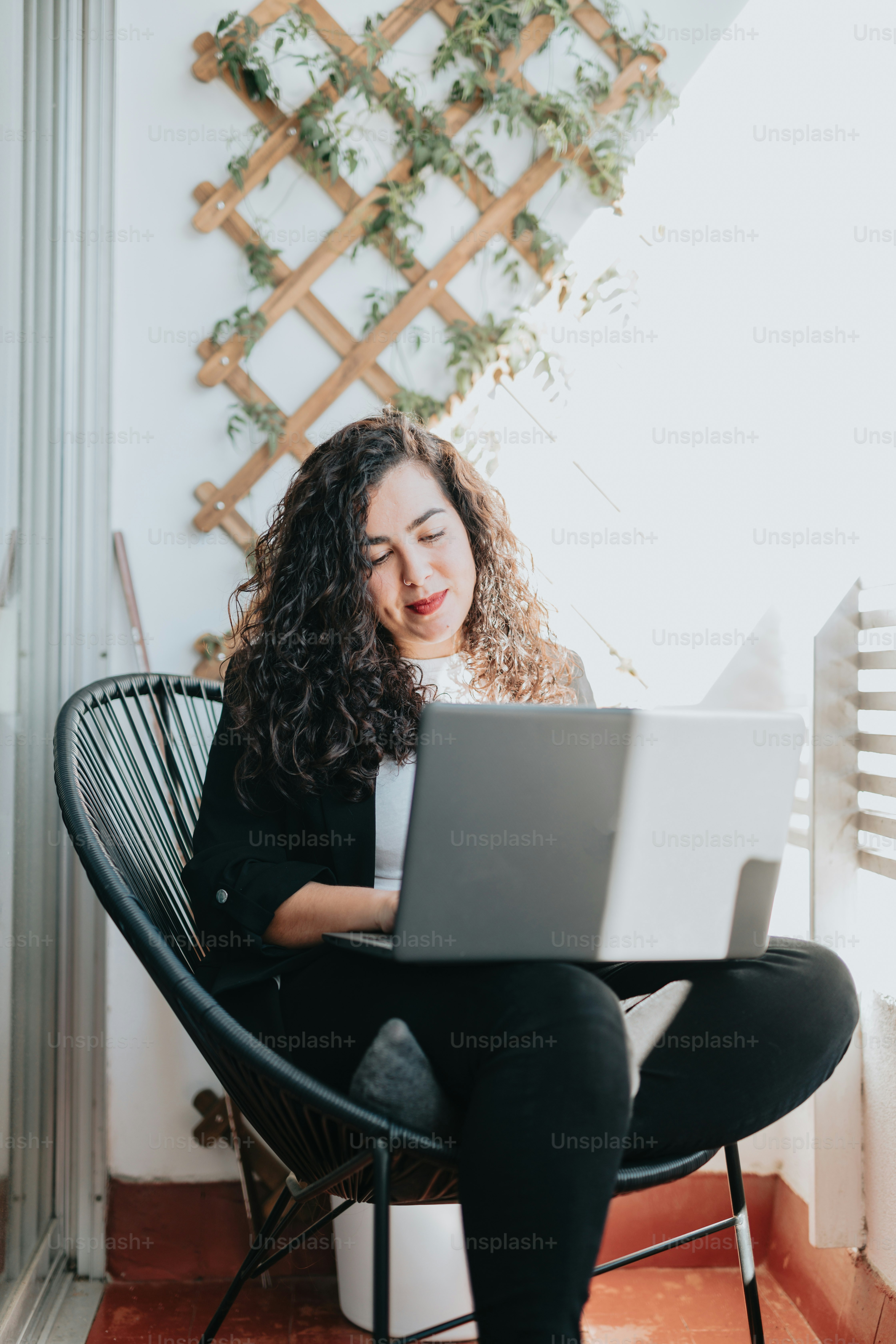 A woman sitting in a chair using a laptop photo – Manager Image on Unsplash