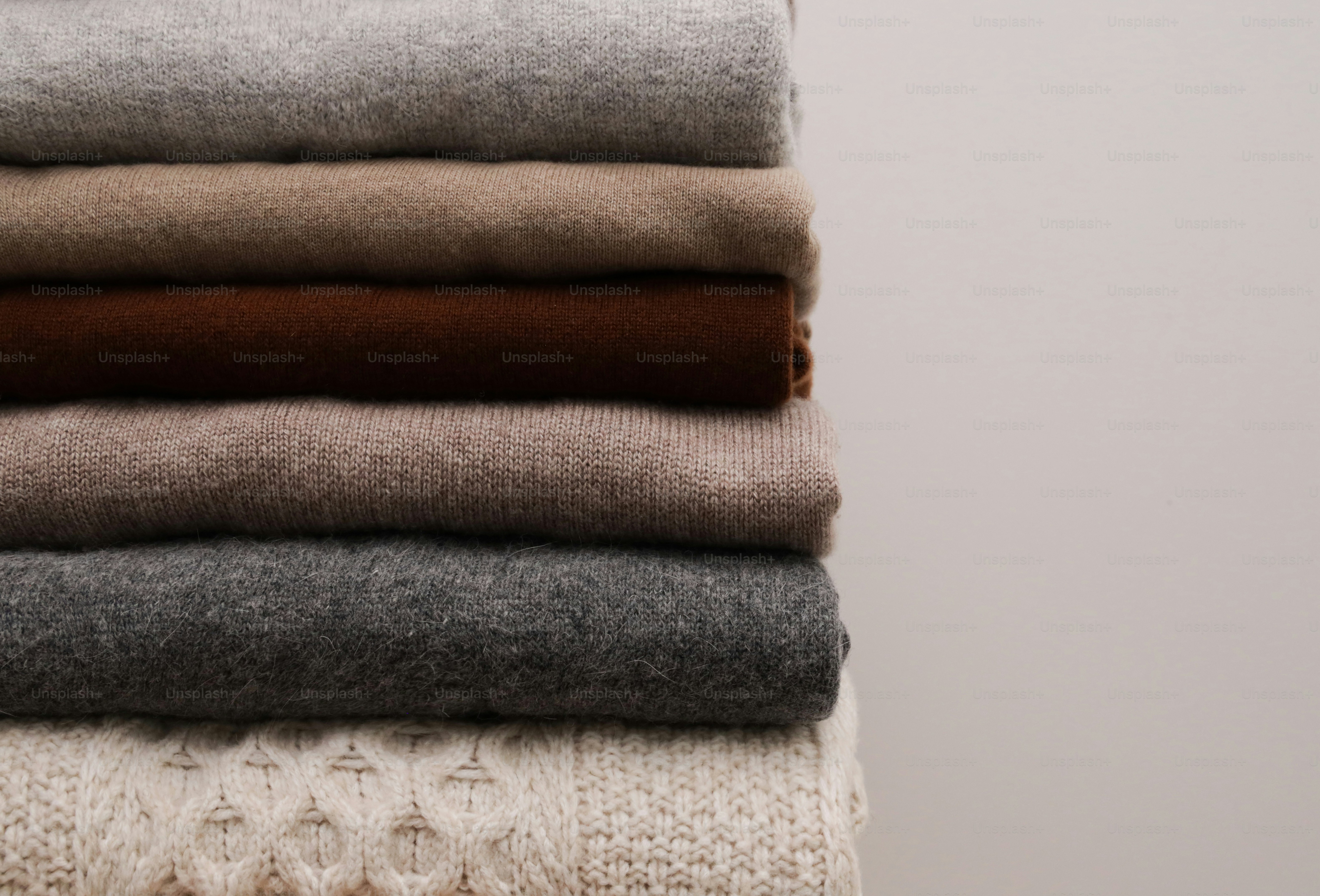 A stack of sweaters sitting on top of each other photo – Winter Image ...