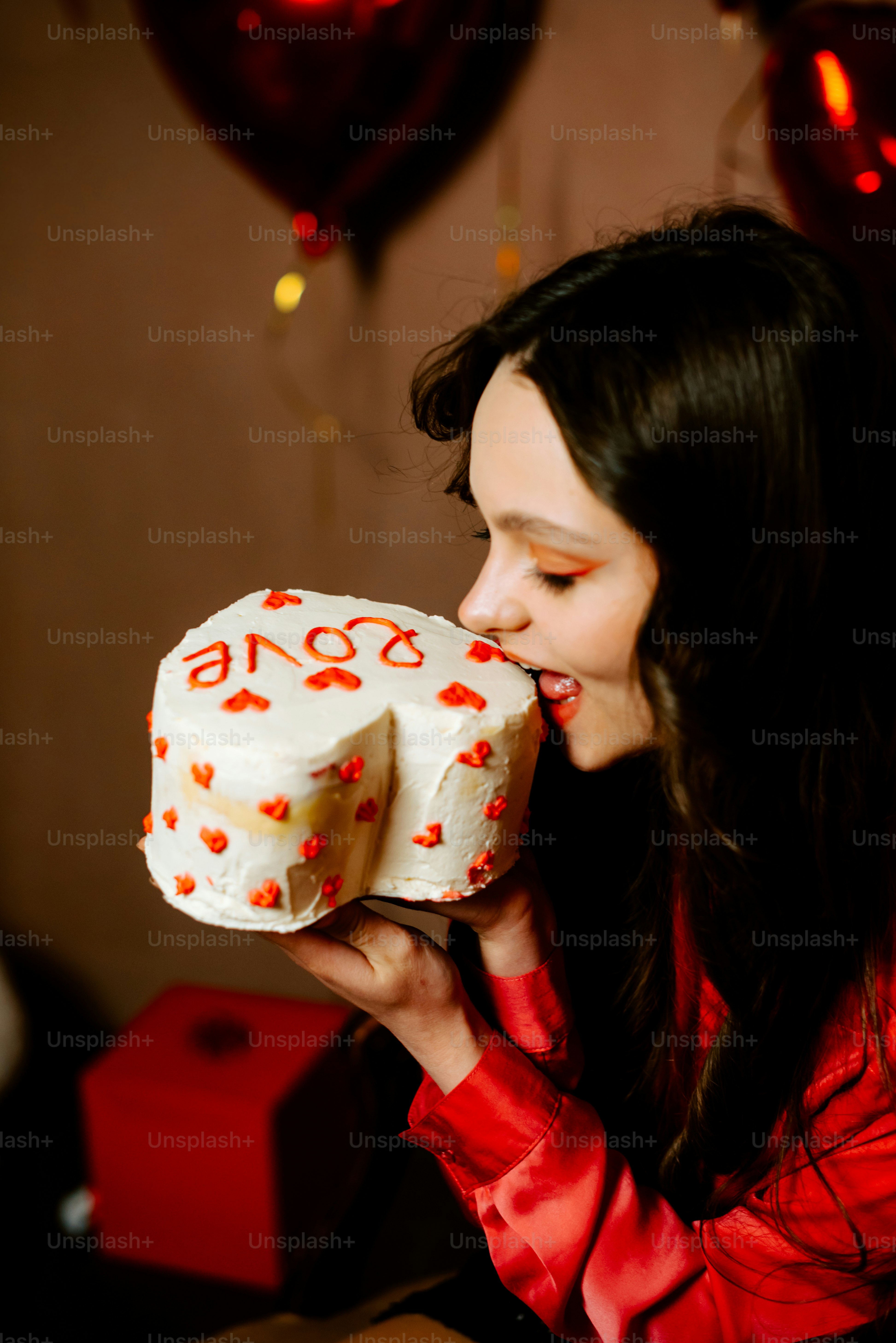 A woman biting into a cake with hearts on it photo – Love Image on Unsplash