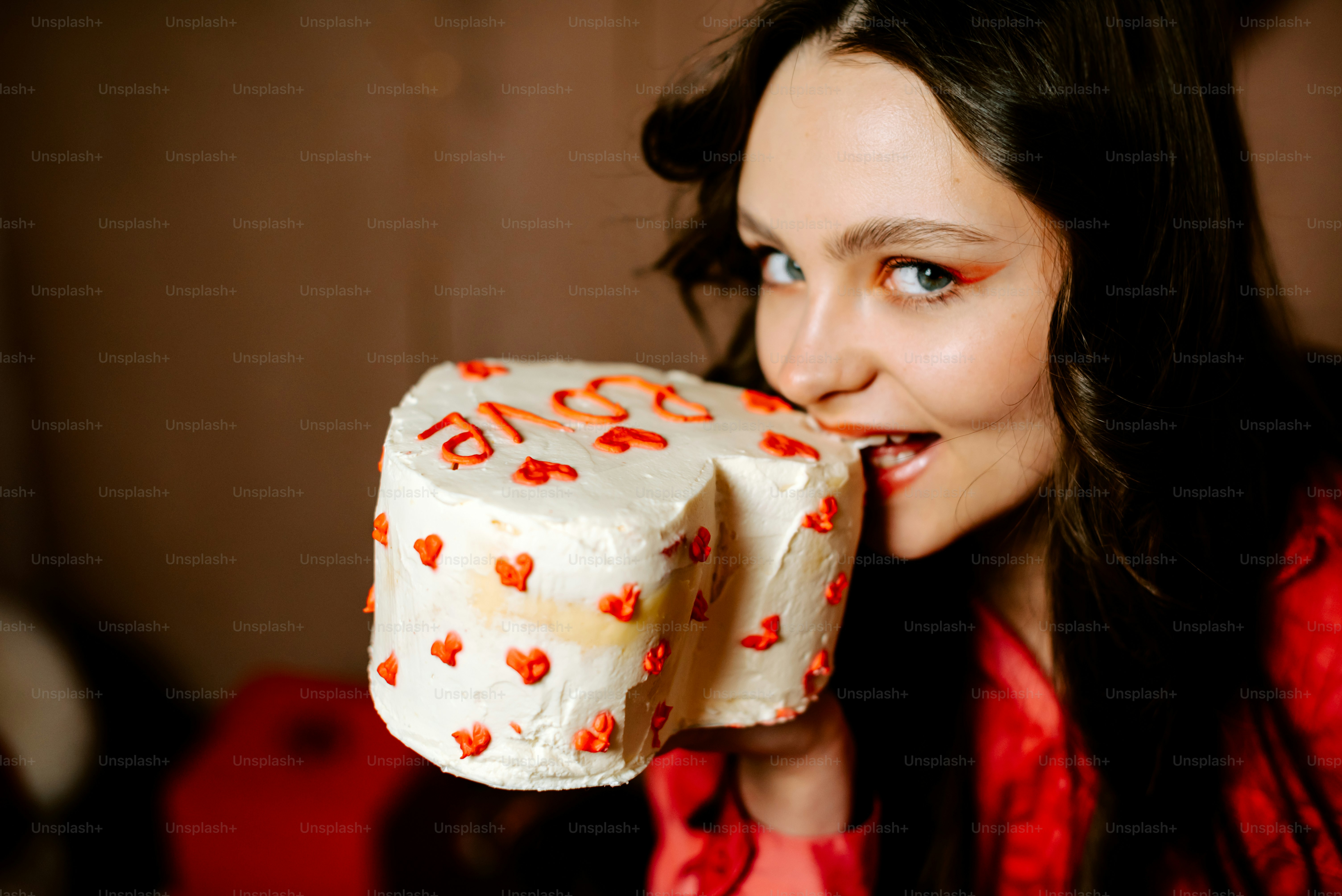 A woman biting into a cake with hearts on it photo – Valentines Image ...