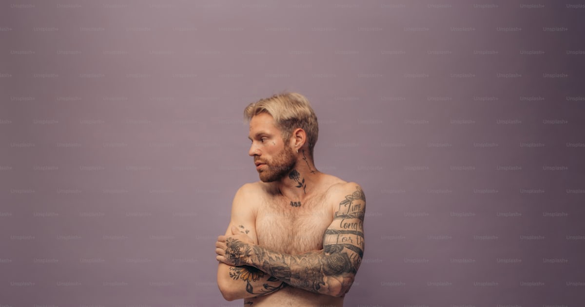 紫の背景の前に立つ入れ墨の腕を持つ男の写真 入れ墨 Unsplashの写真