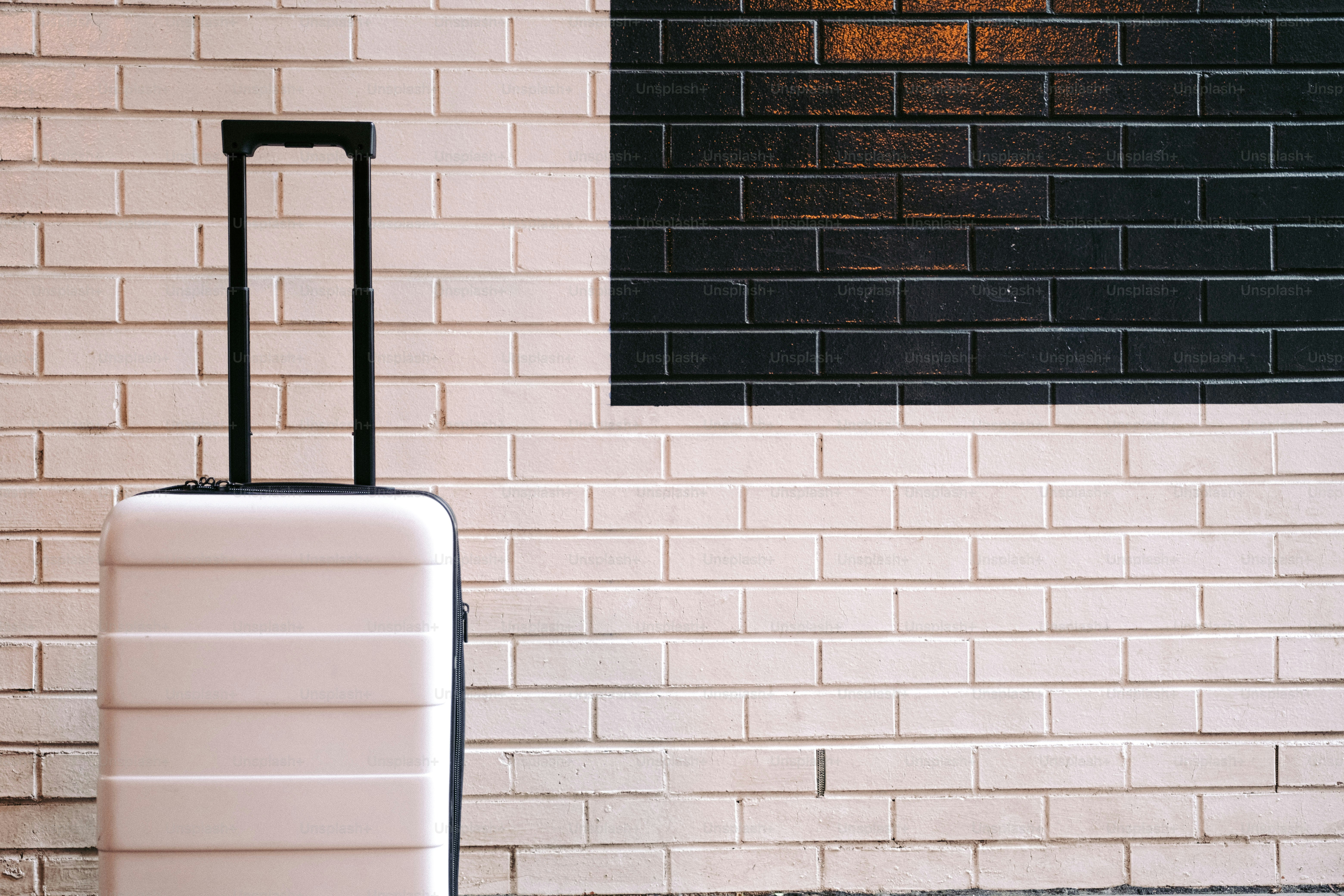 A piece of luggage sitting in front of a brick wall photo – Travel ...