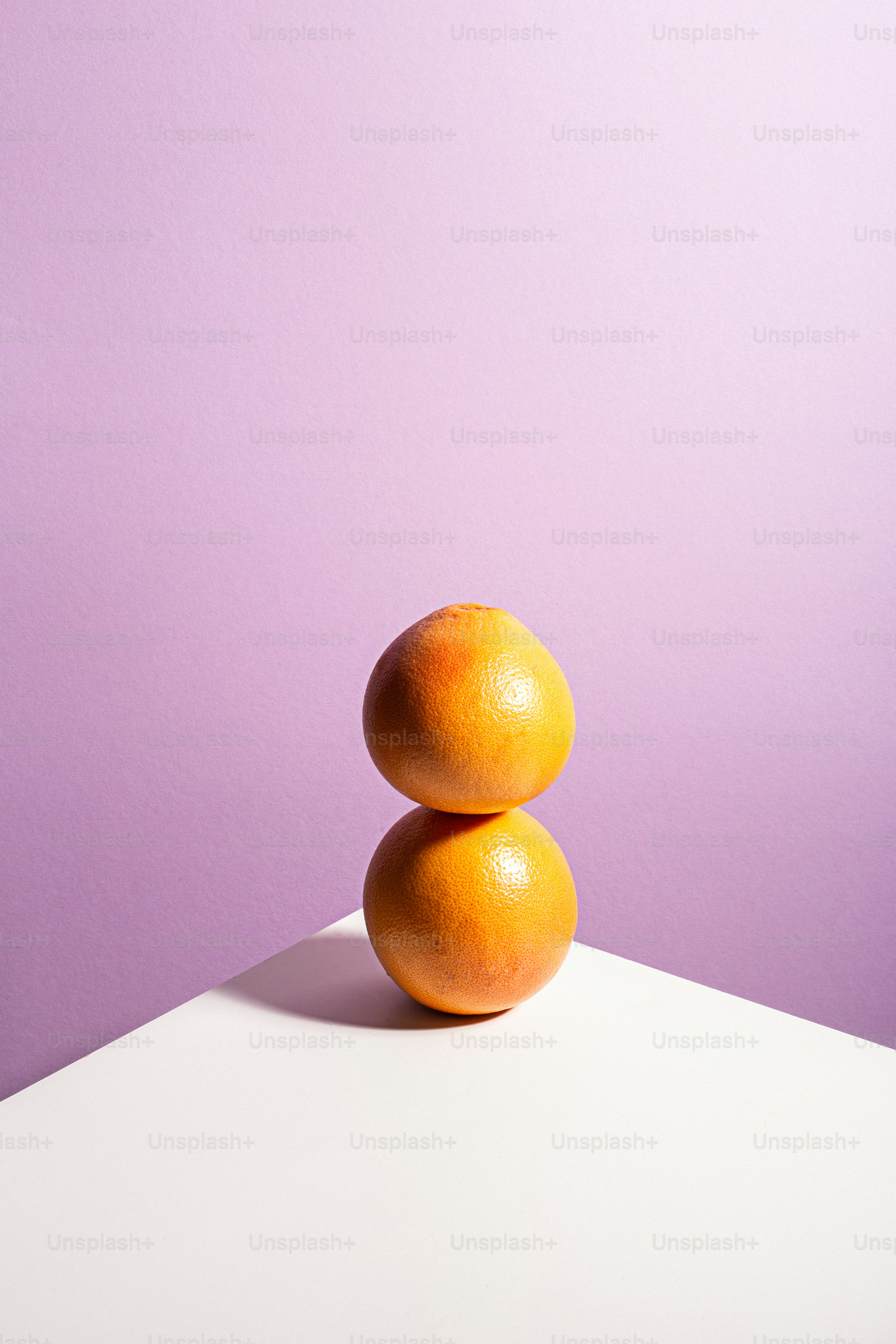 Two oranges stacked on top of each other on a table photo – Fruits ...
